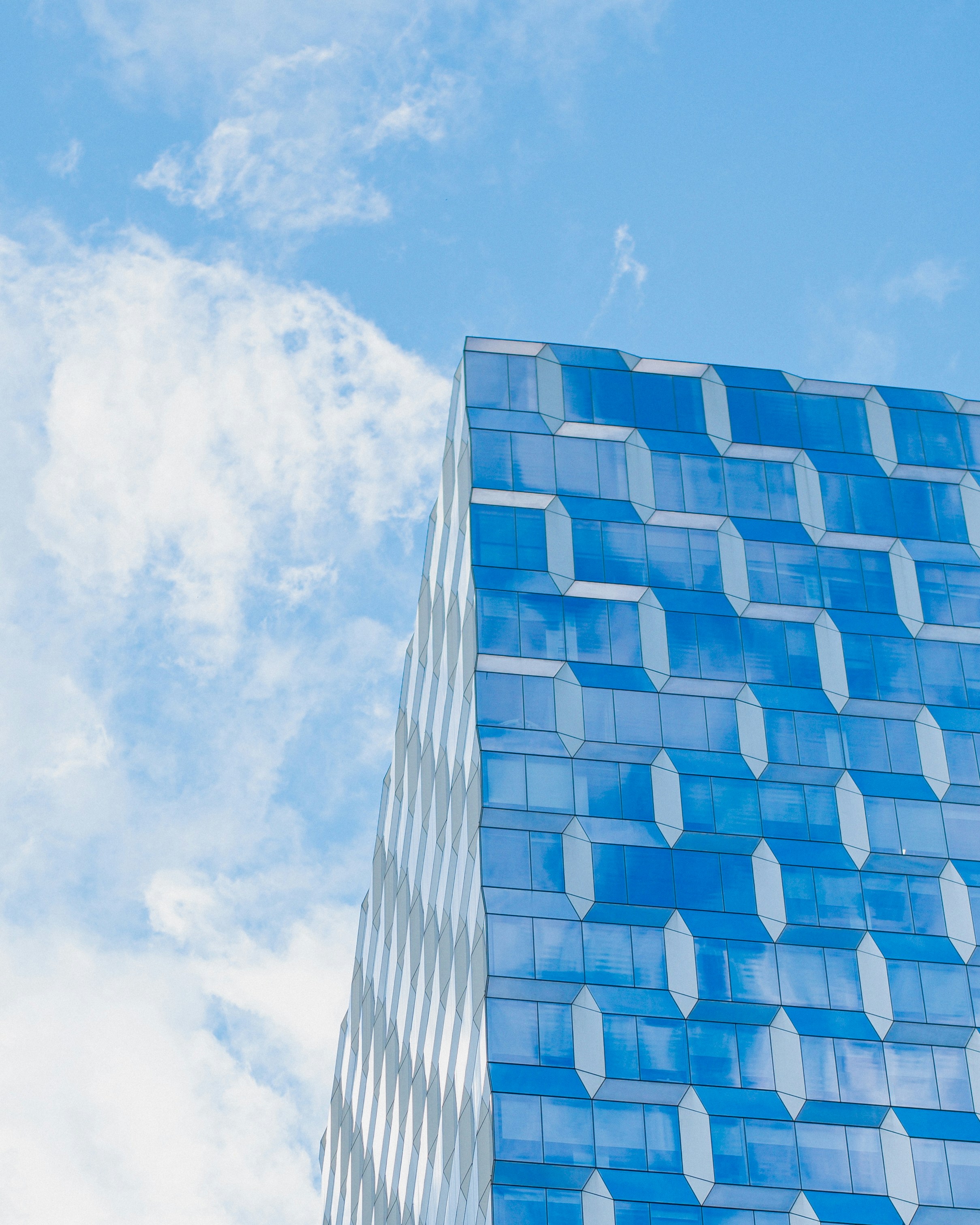 Blue Facade Geometry Rising into a Bright Sky