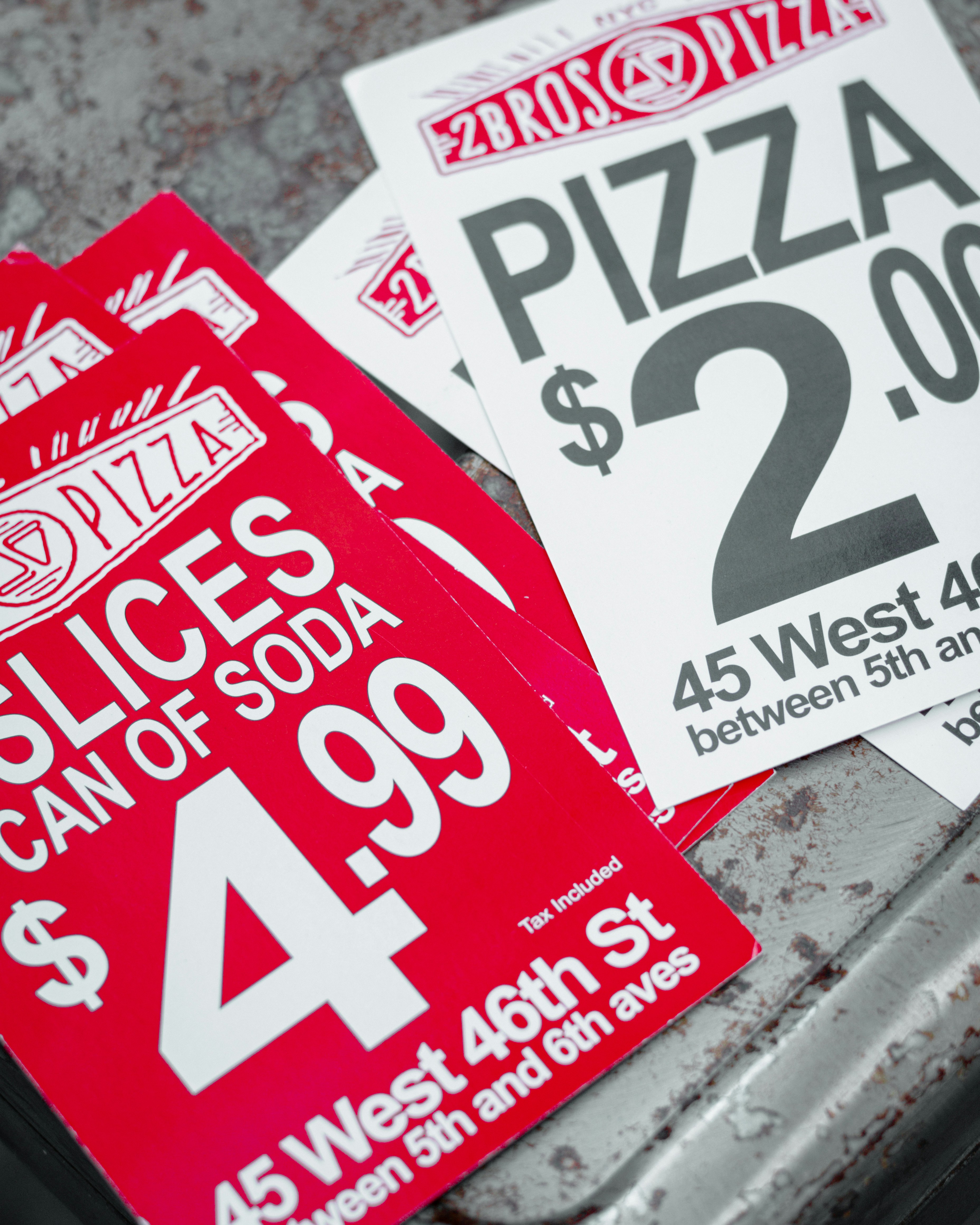 Pizza Price Codes: Red and White Flyers Scattered on a Concrete Surface
