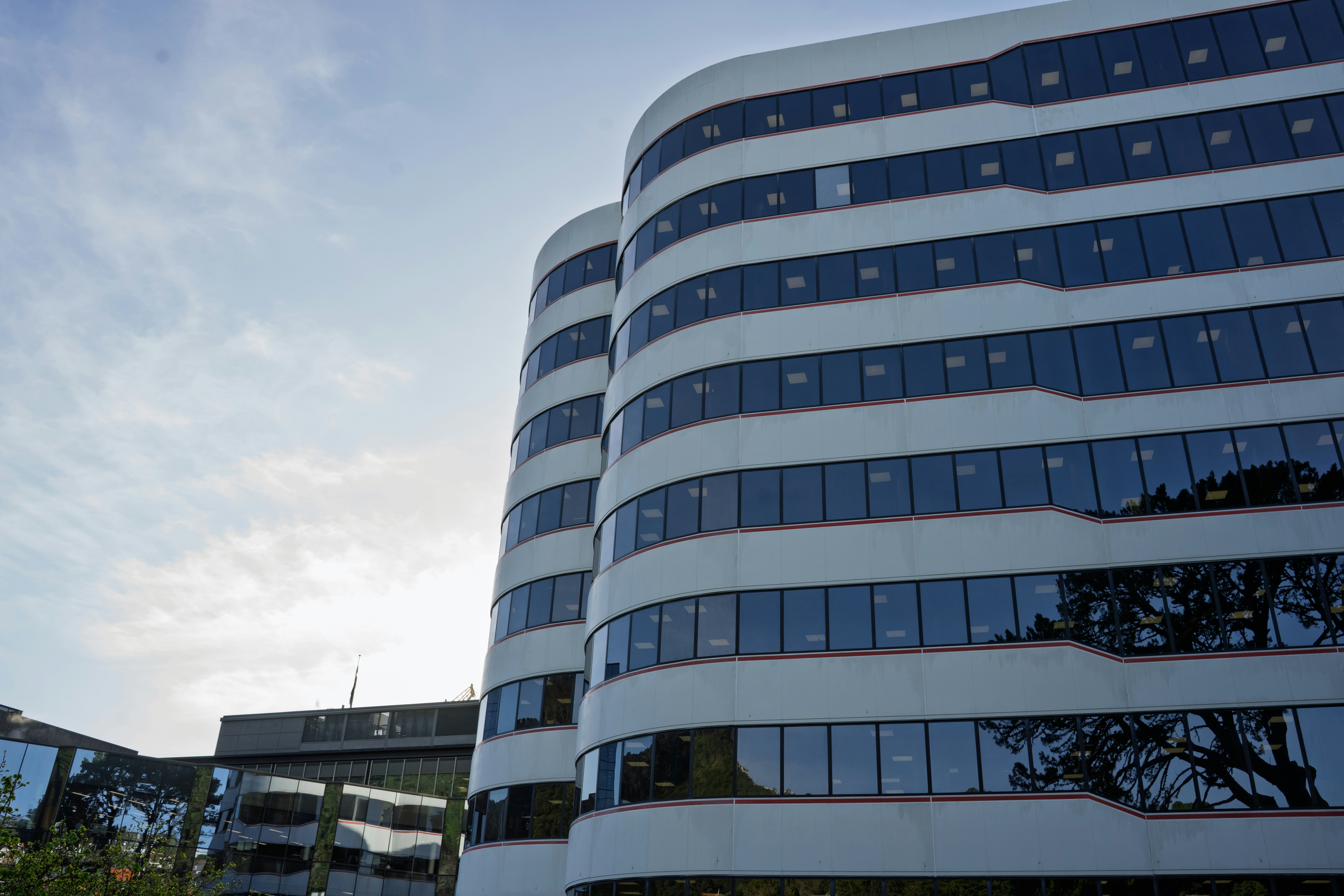 Curved Glass Facade: A Modern Corporate Capsule Rrowning the Sky