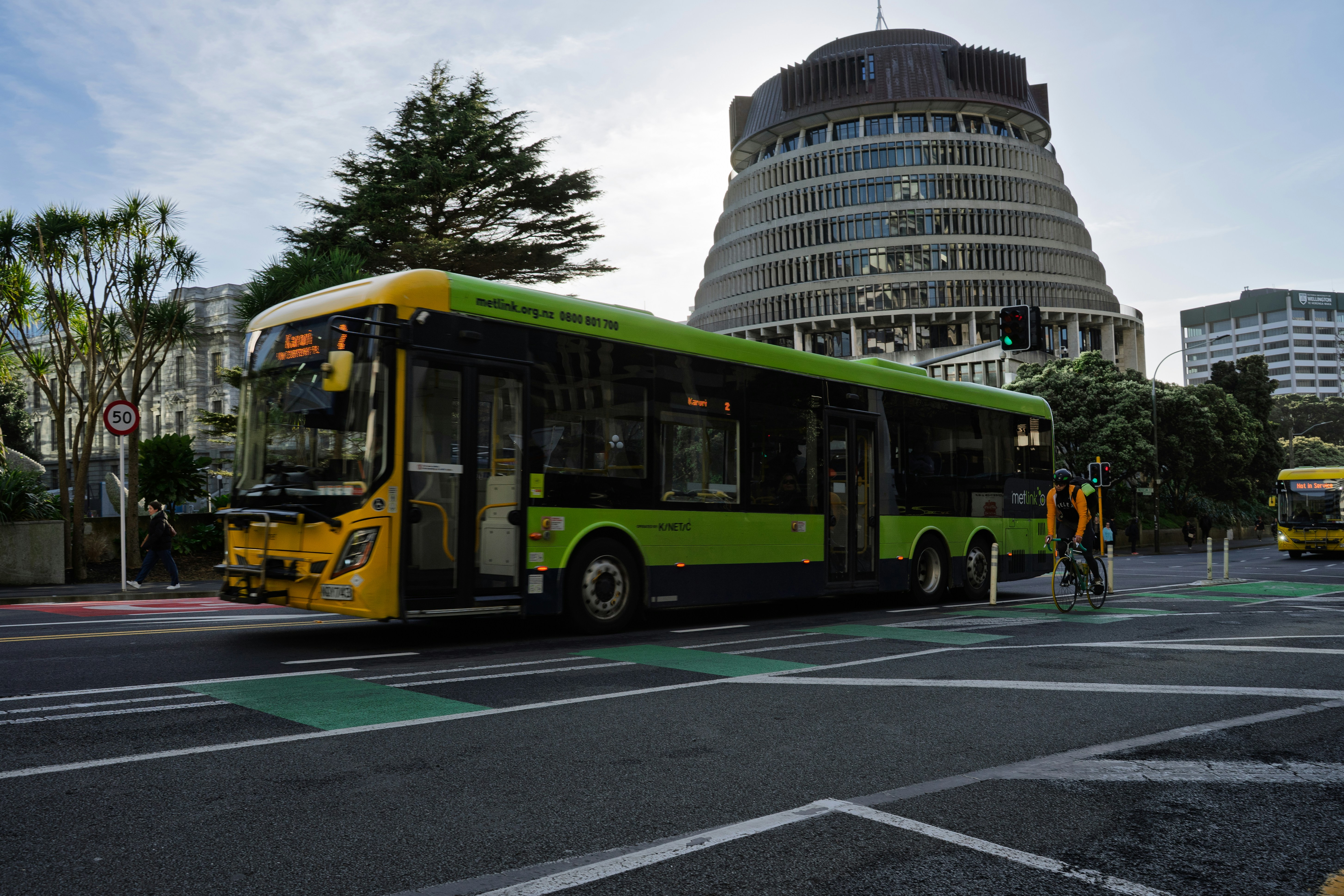 Green City Bus at the Modern Circular Building Crossing