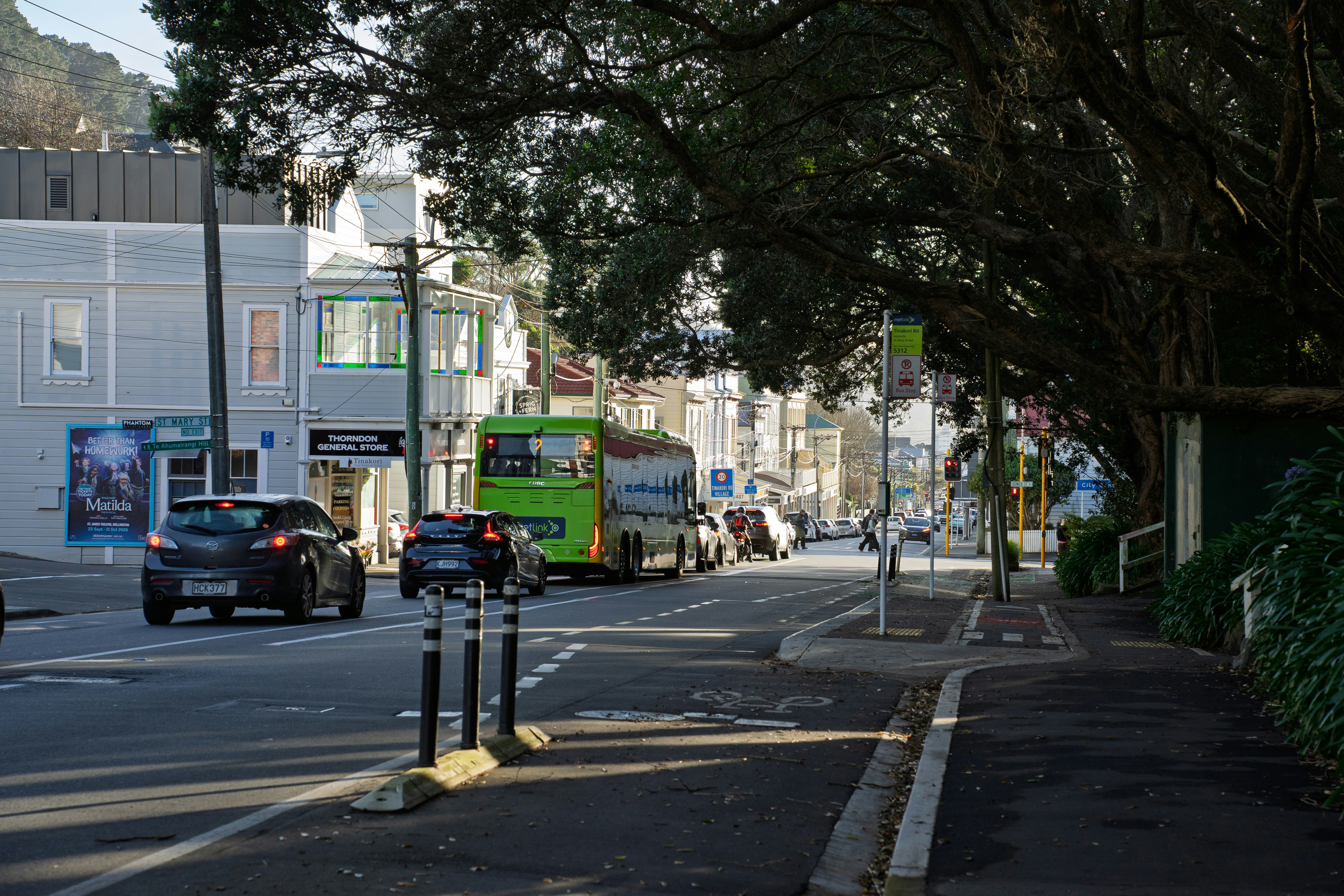 City Street in Dappled Shade with Transit Bus and Vehicles