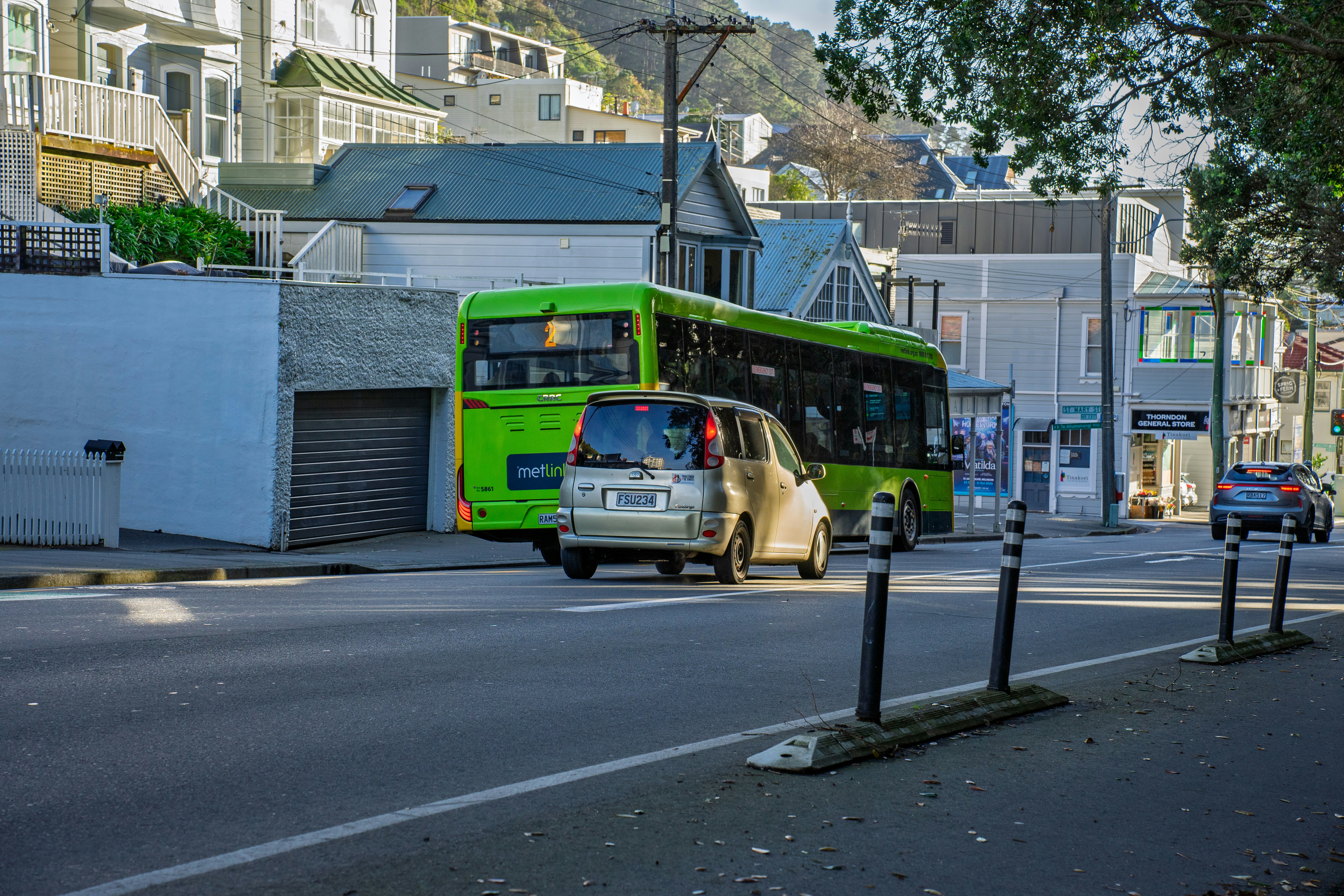 Green City Bus Punctuating a Quiet Urban Street