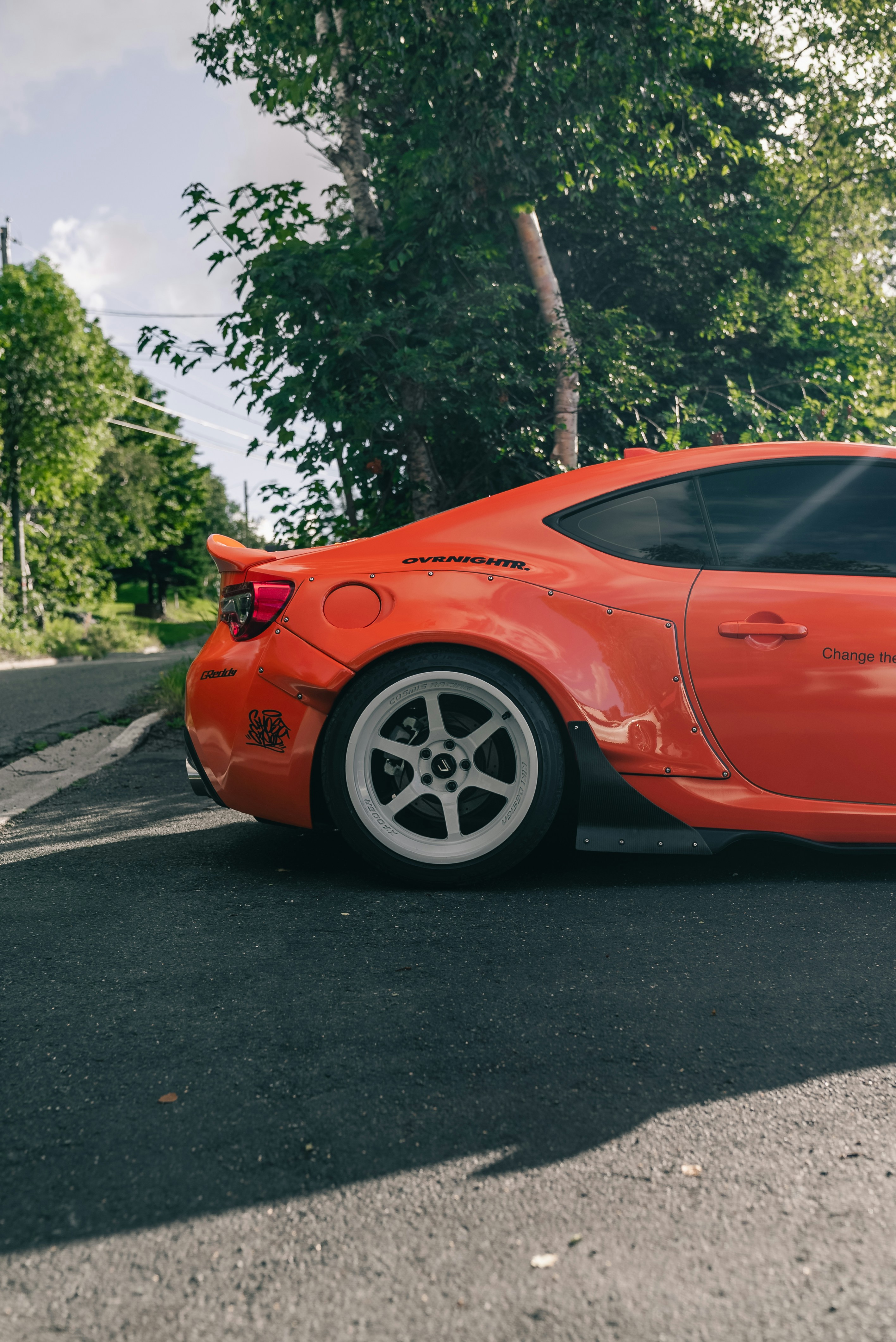 Rear Corner Power: A Burnished Orange Porshe-Like Coupe Anchors a Quiet Parking Lot
