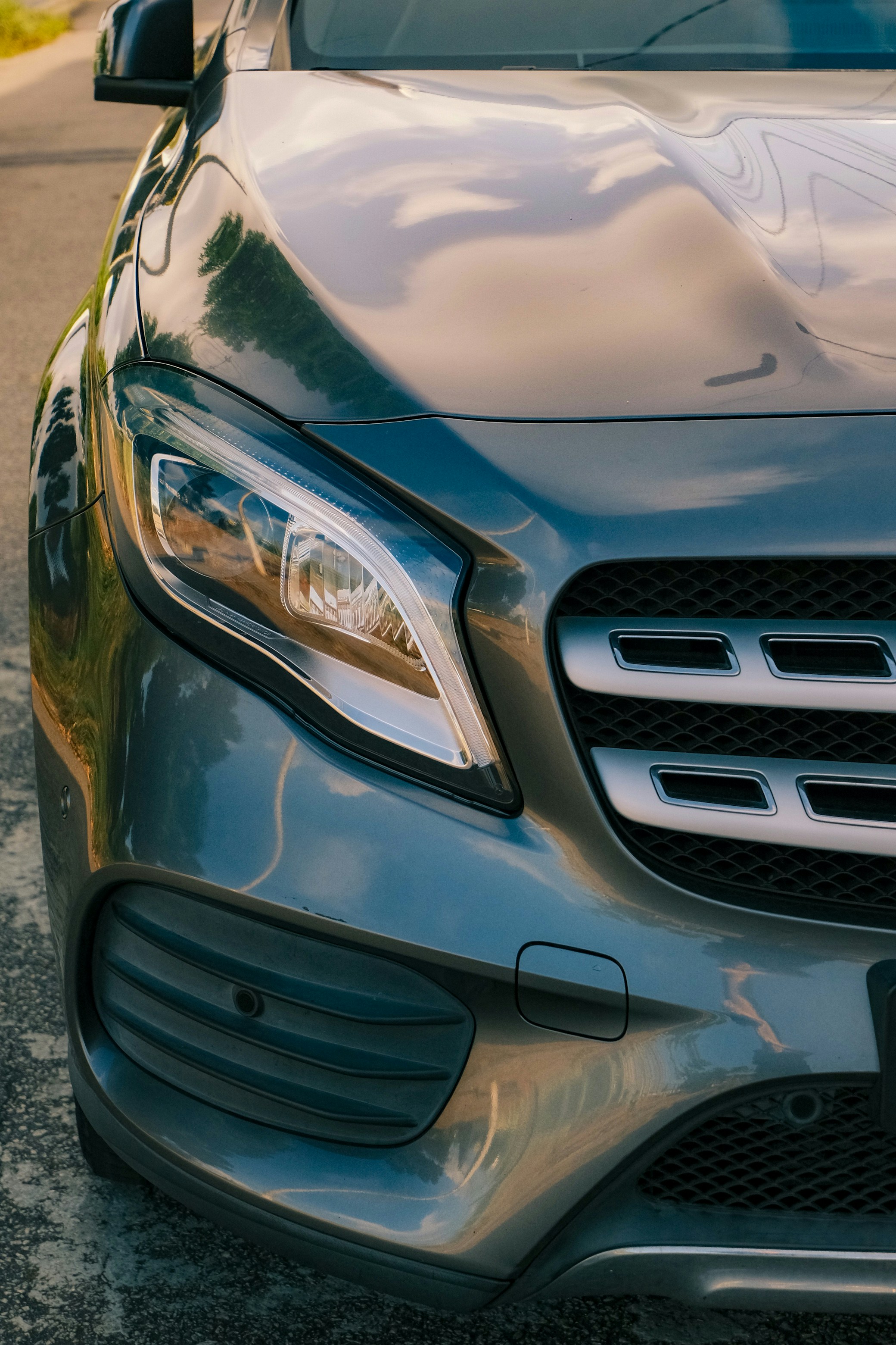 Close-Up of a Modern SUV Front Emblem and Headlamp with Reflections