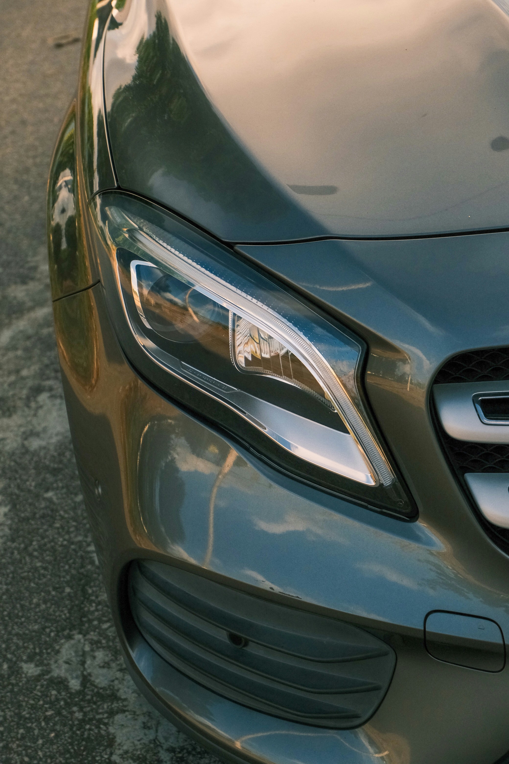 Curved Grille and Headlamp Portrait on a Dark Metallic Vehicle