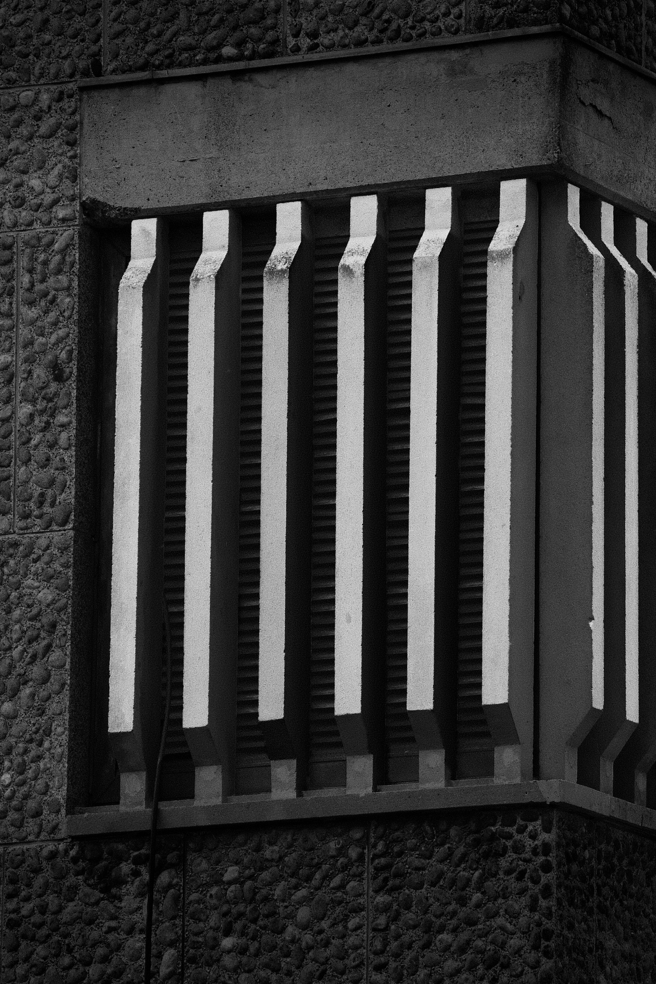 Monolithic Ribbing: Vertical Struts on a Textured Concrete Corner