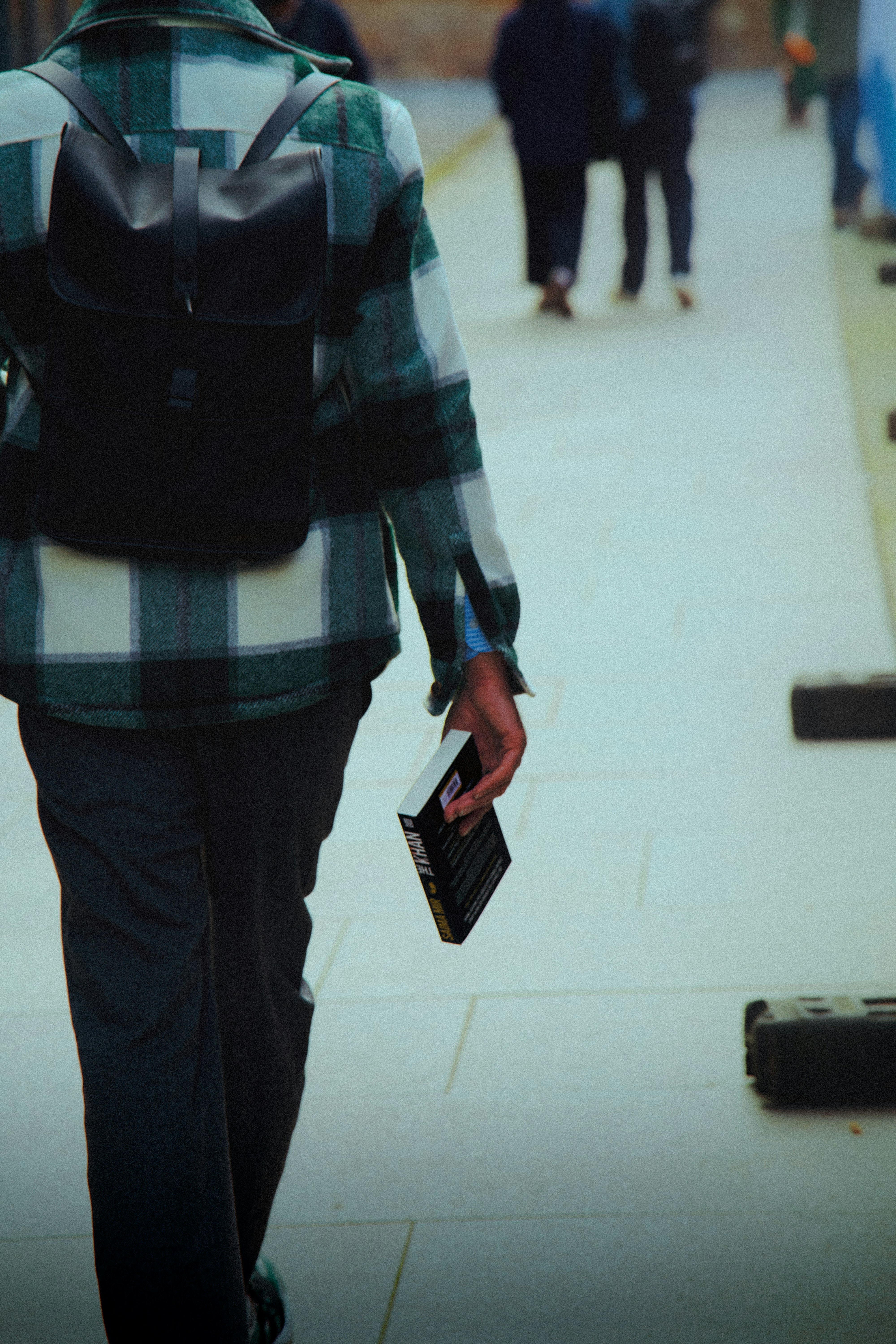 Backpack Walk: A Casual Moment with a Box in Hand