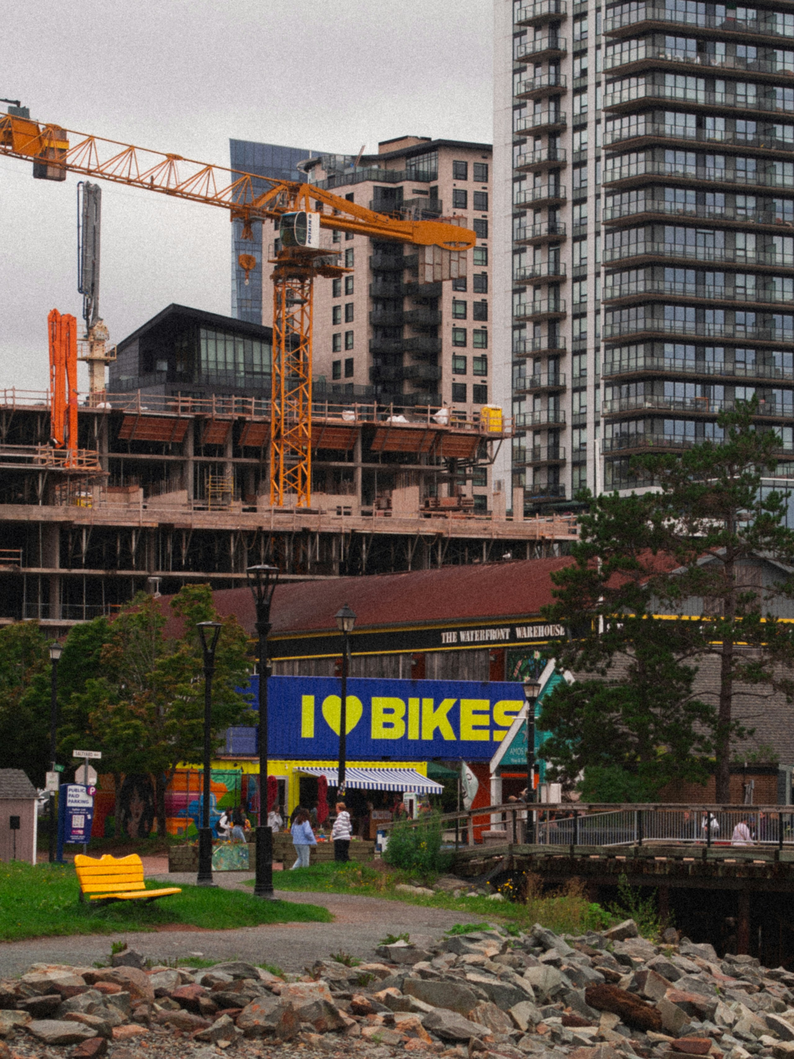 Urban Construction Wake: A Riverfront Playground Beneath Towering Cranes