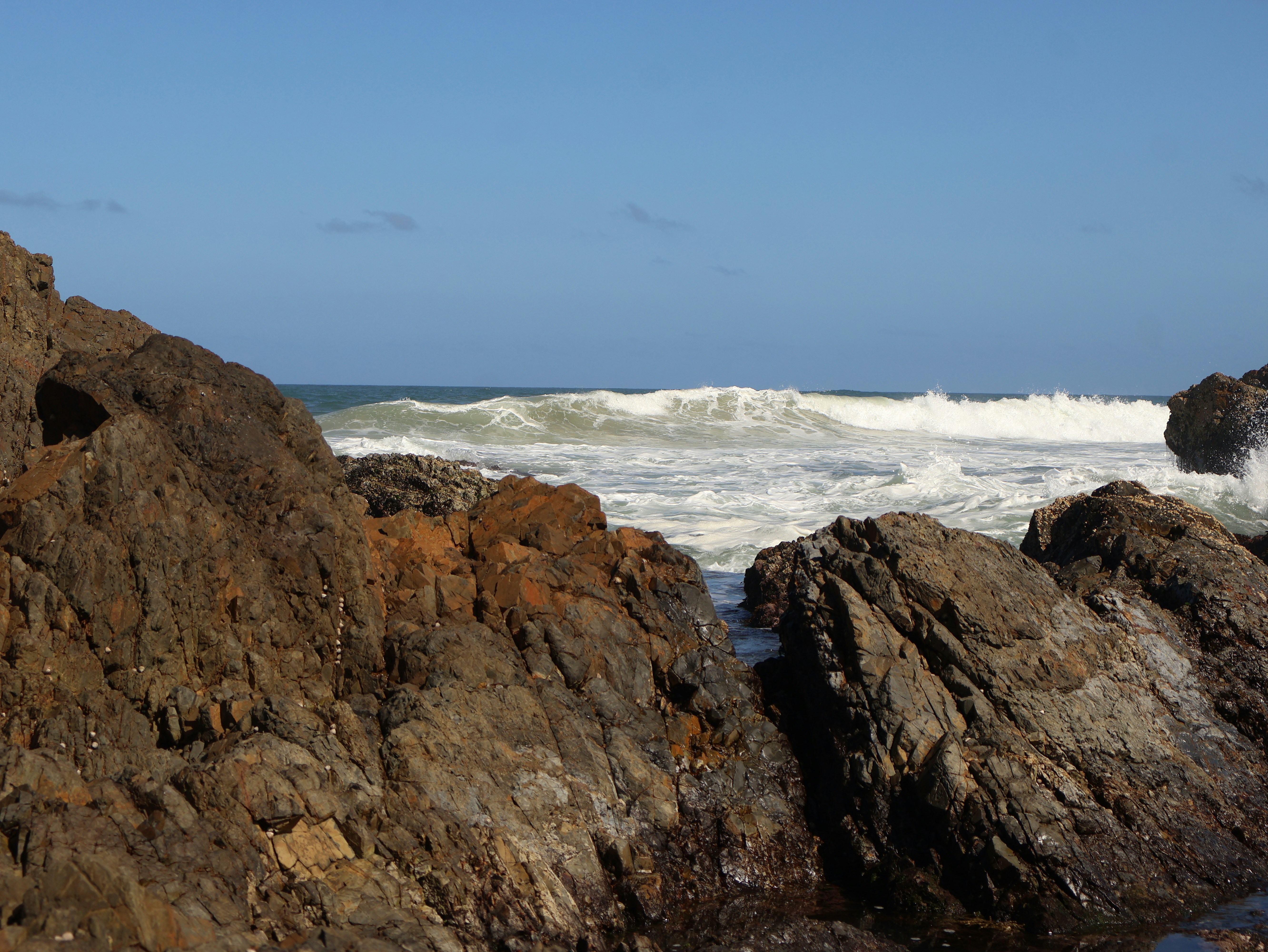 Rugged Coastal Geometry: Waves Breaking Over Weathered Rocks