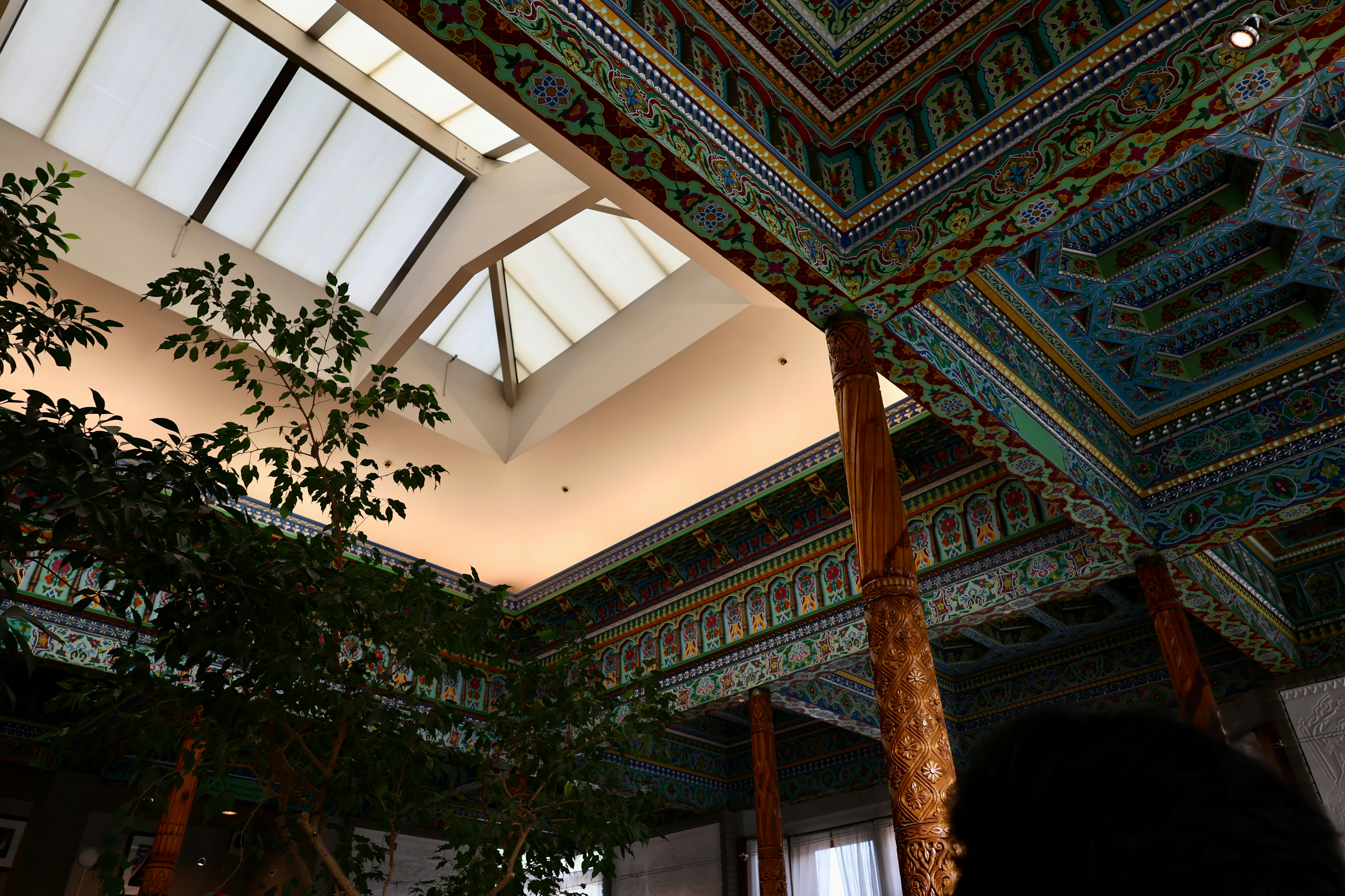 Ornate Temple Ceiling Framing Above a Courtyard Arboretum