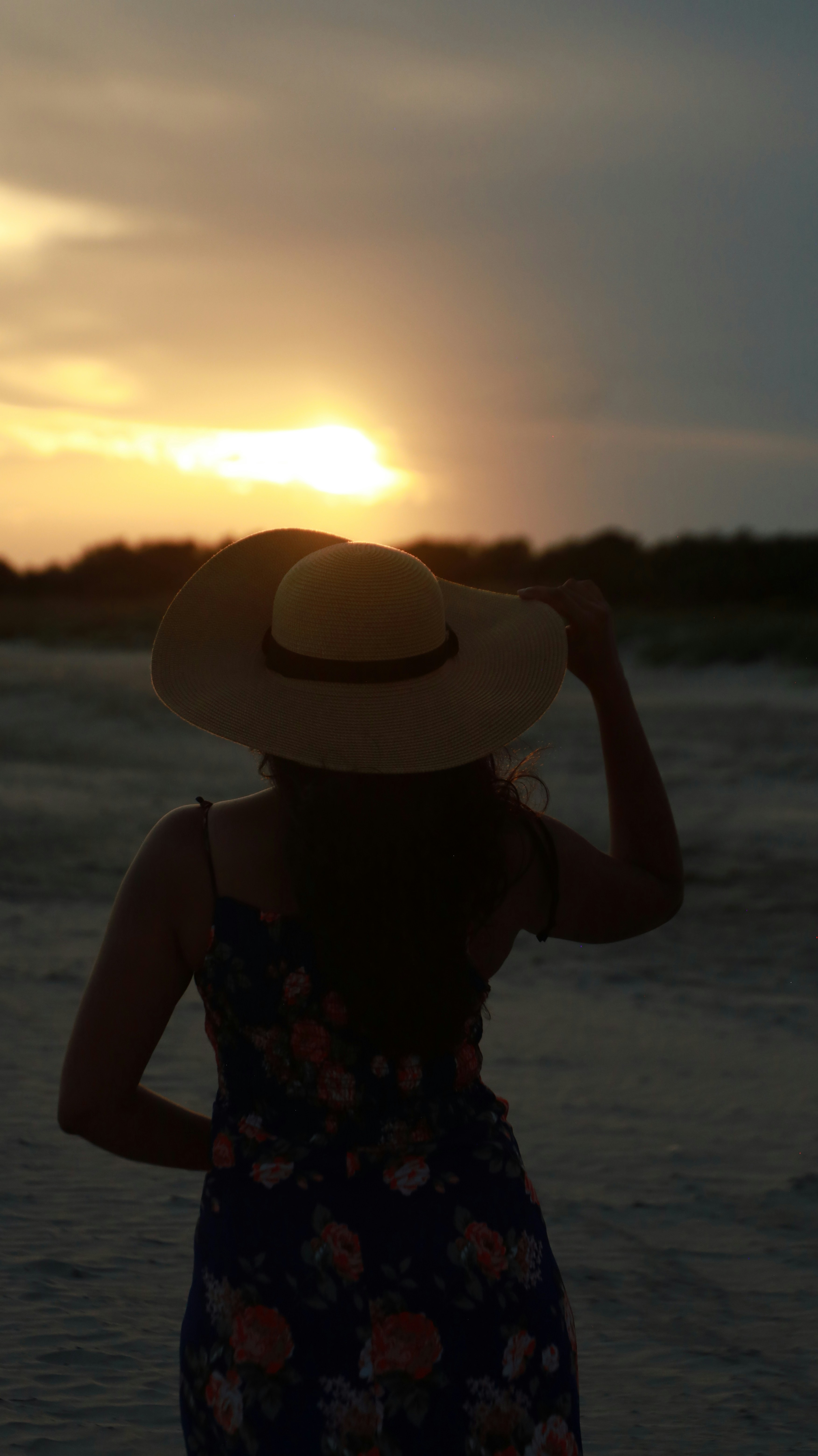 Sunset Silhouette: A Woman in a Floral Dress at the Dune Horizon