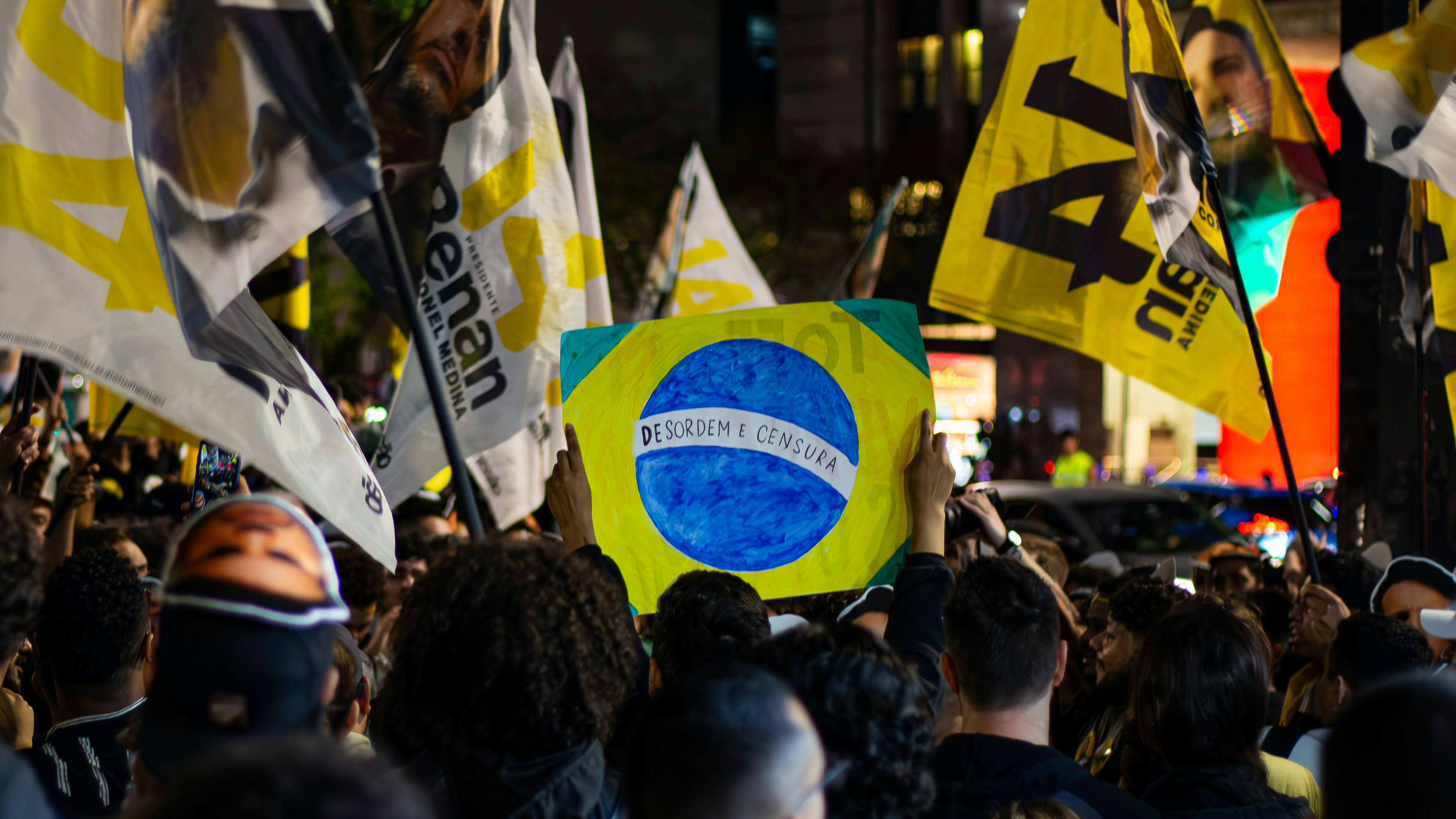 Blue Banner Amid a Night Market of Flags and Silence-breaking Voices