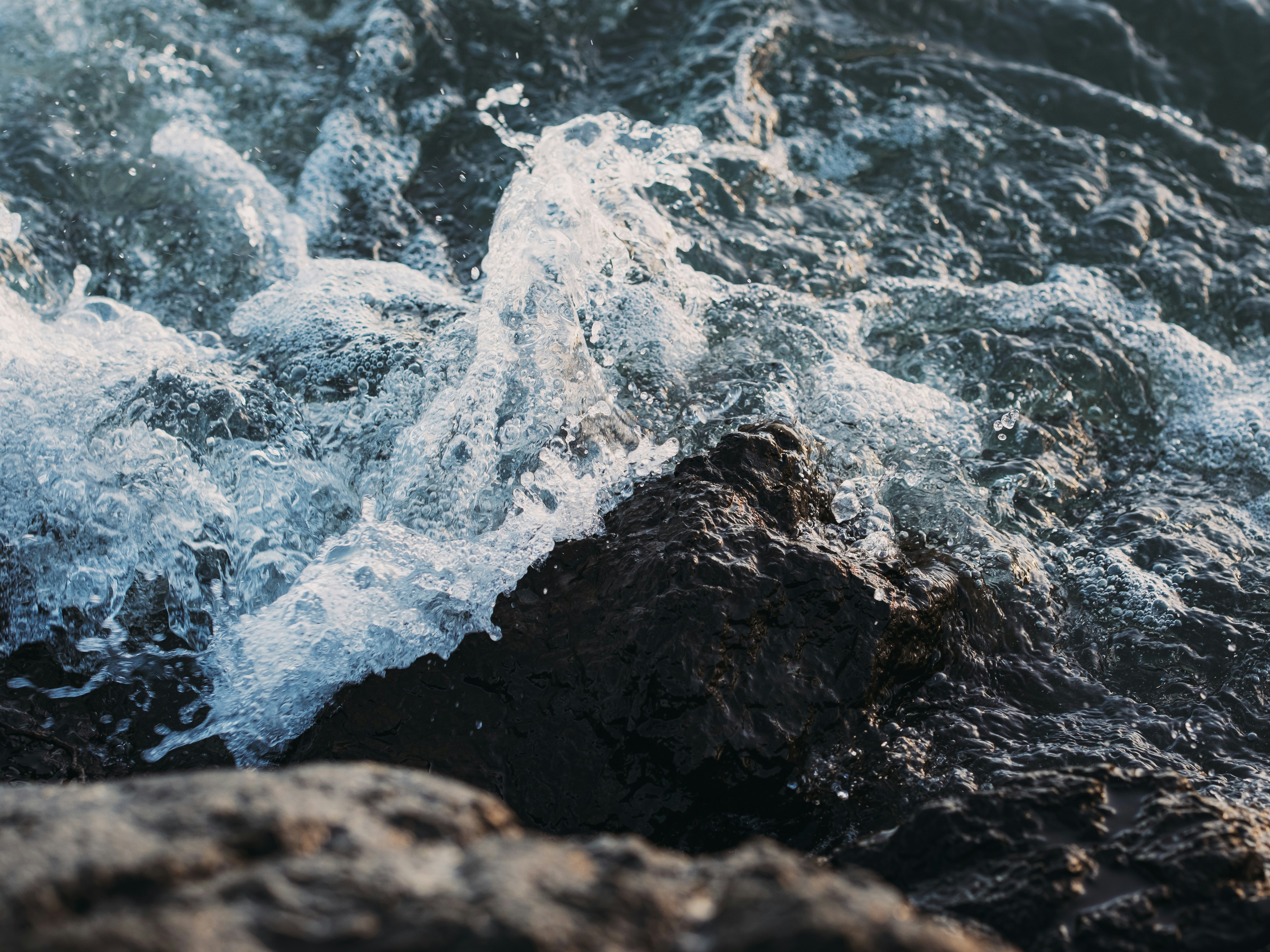 Rugged High Tide: Foam Fractures on Dark Reef
