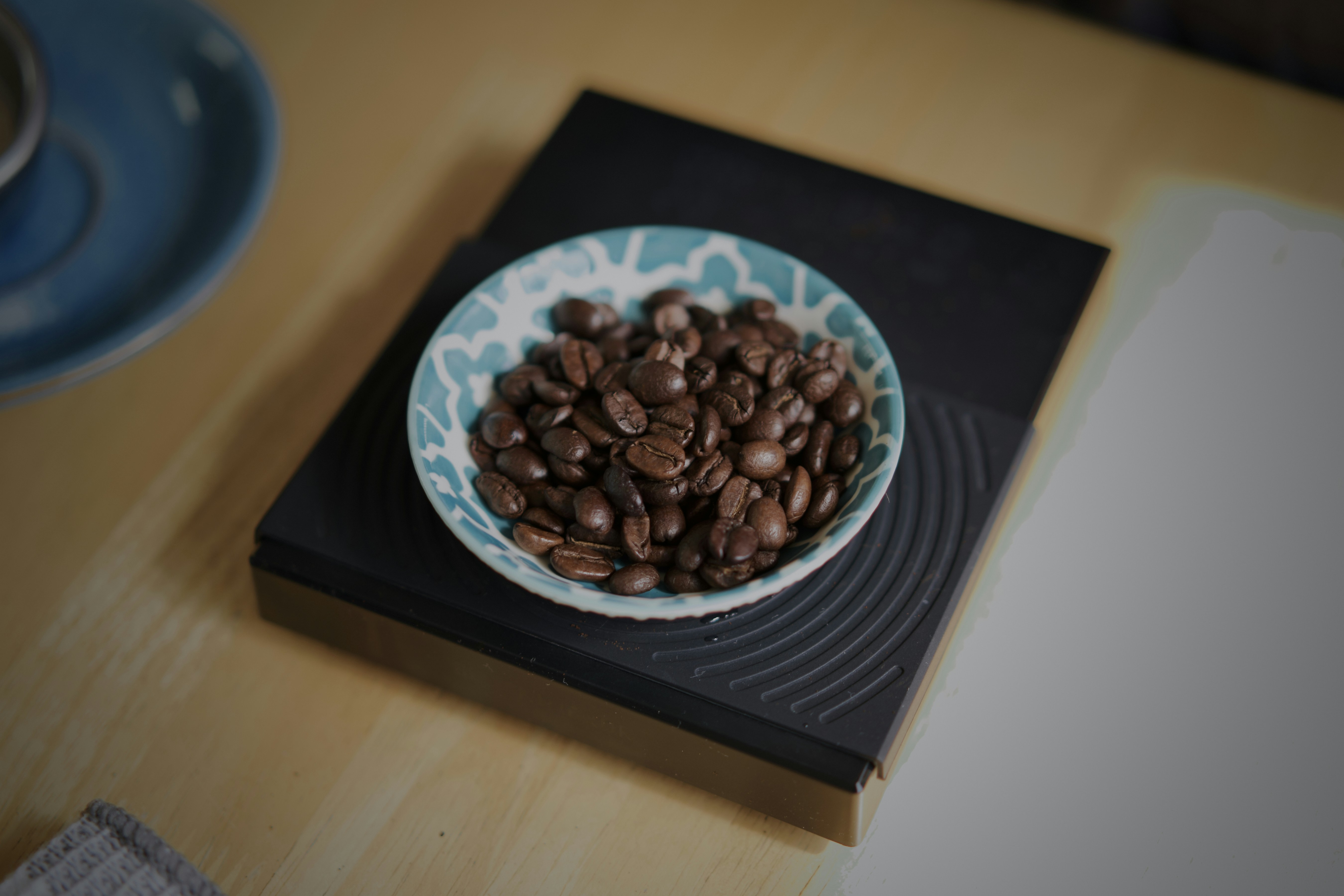 Coffee Beans in a Decorative Bowl on a Wooden Surface