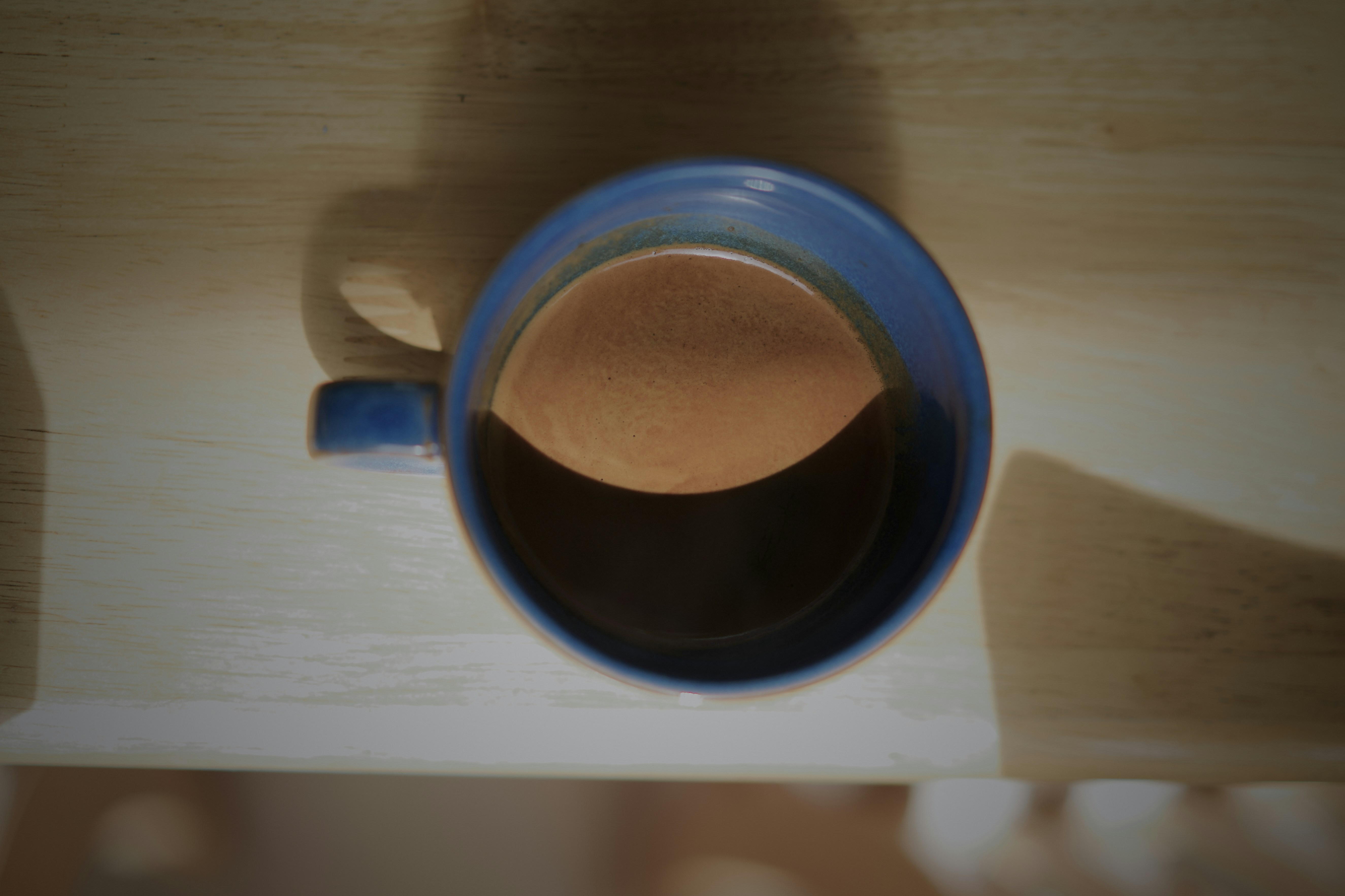 A Top-Down Moment: Blue Mug with Coffee on a Wooden Surface