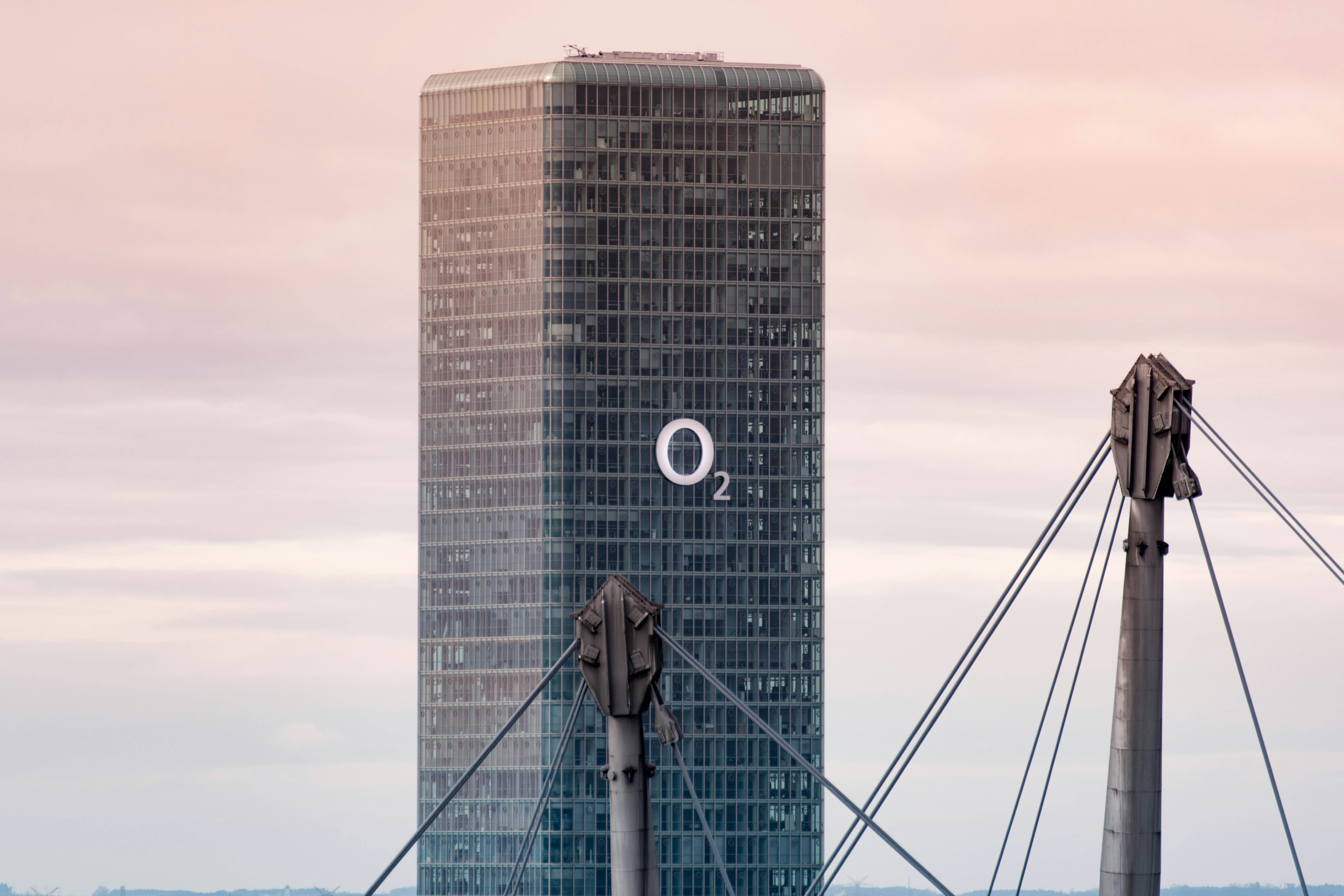 Oxygen Tower: Neon Ring Adrift Above Cables at Dusk
