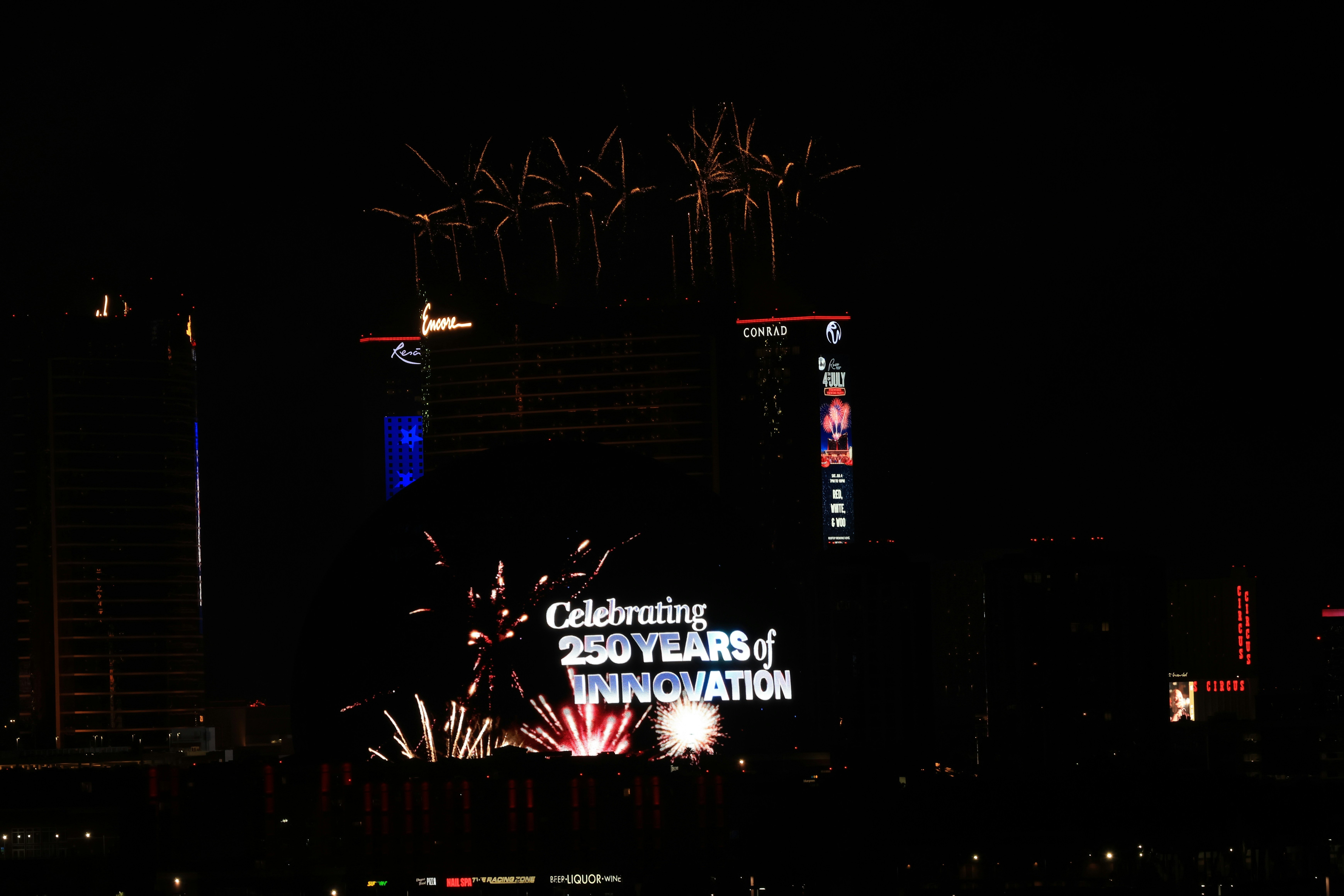 Fireworks over a Neon-Illuminated Billboard Celebrating Innovation