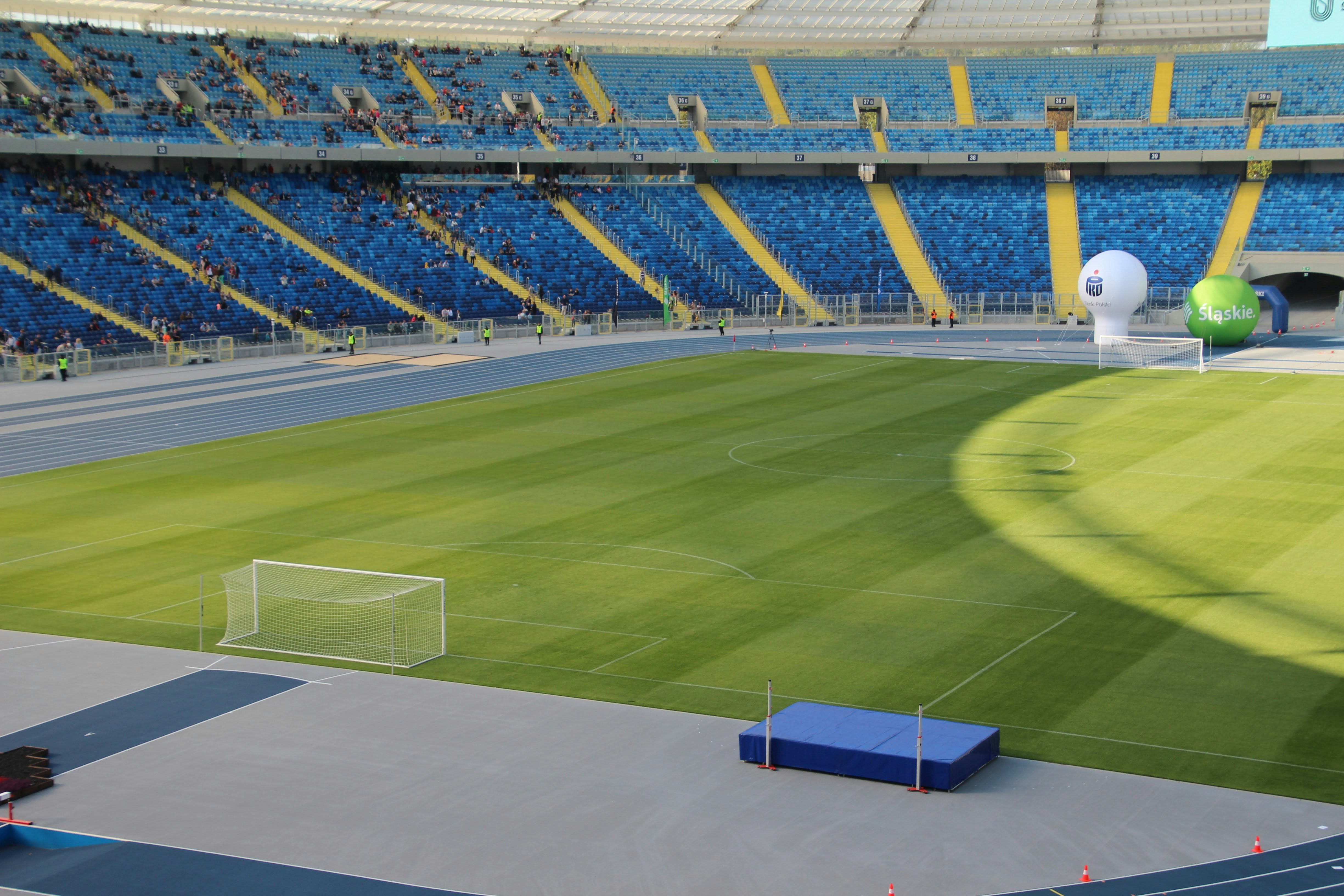 Sunlit Pitch Under Empty Stands with Shadowed Goals