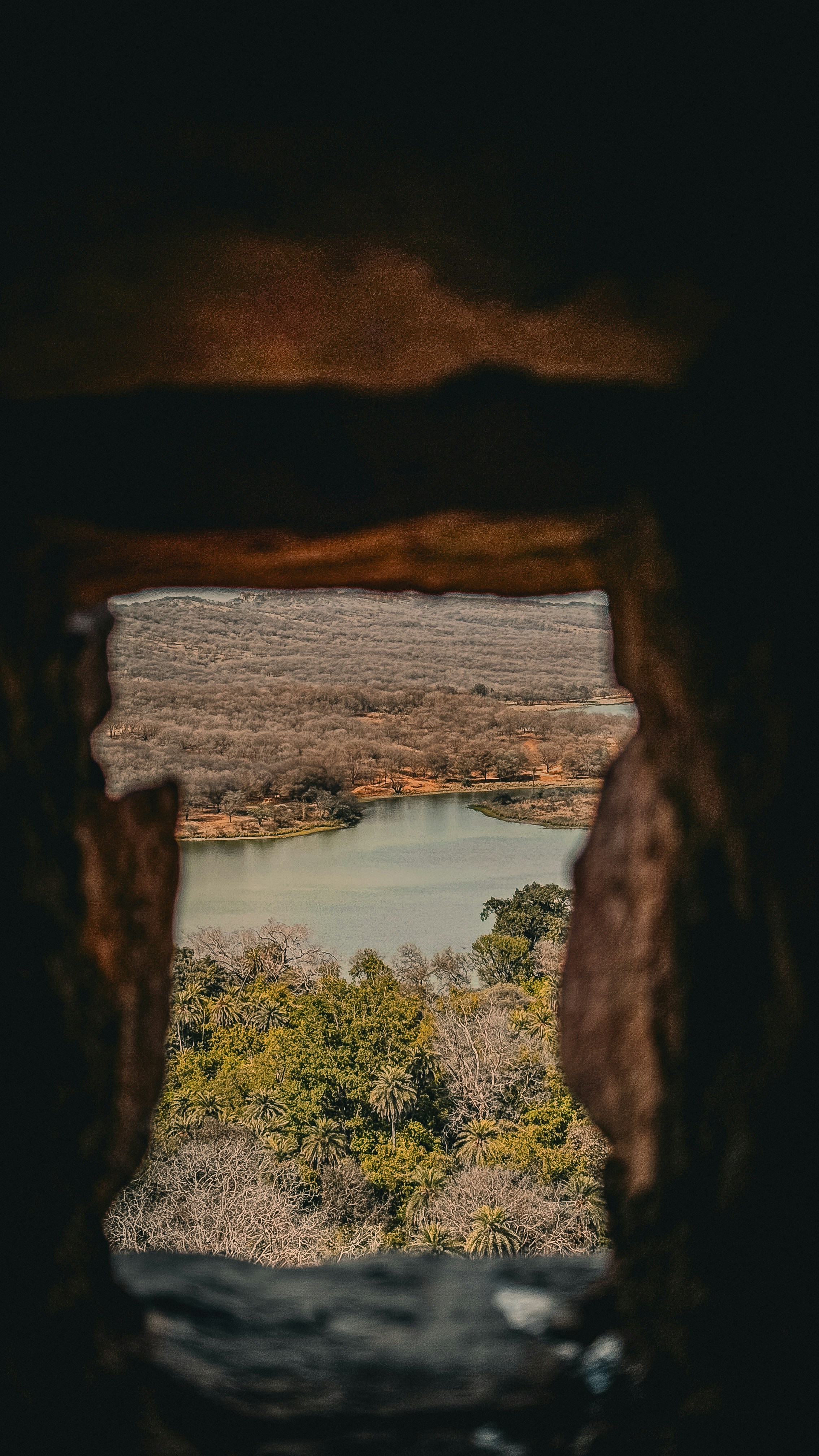 View through a weathered window to a sunlit river valley