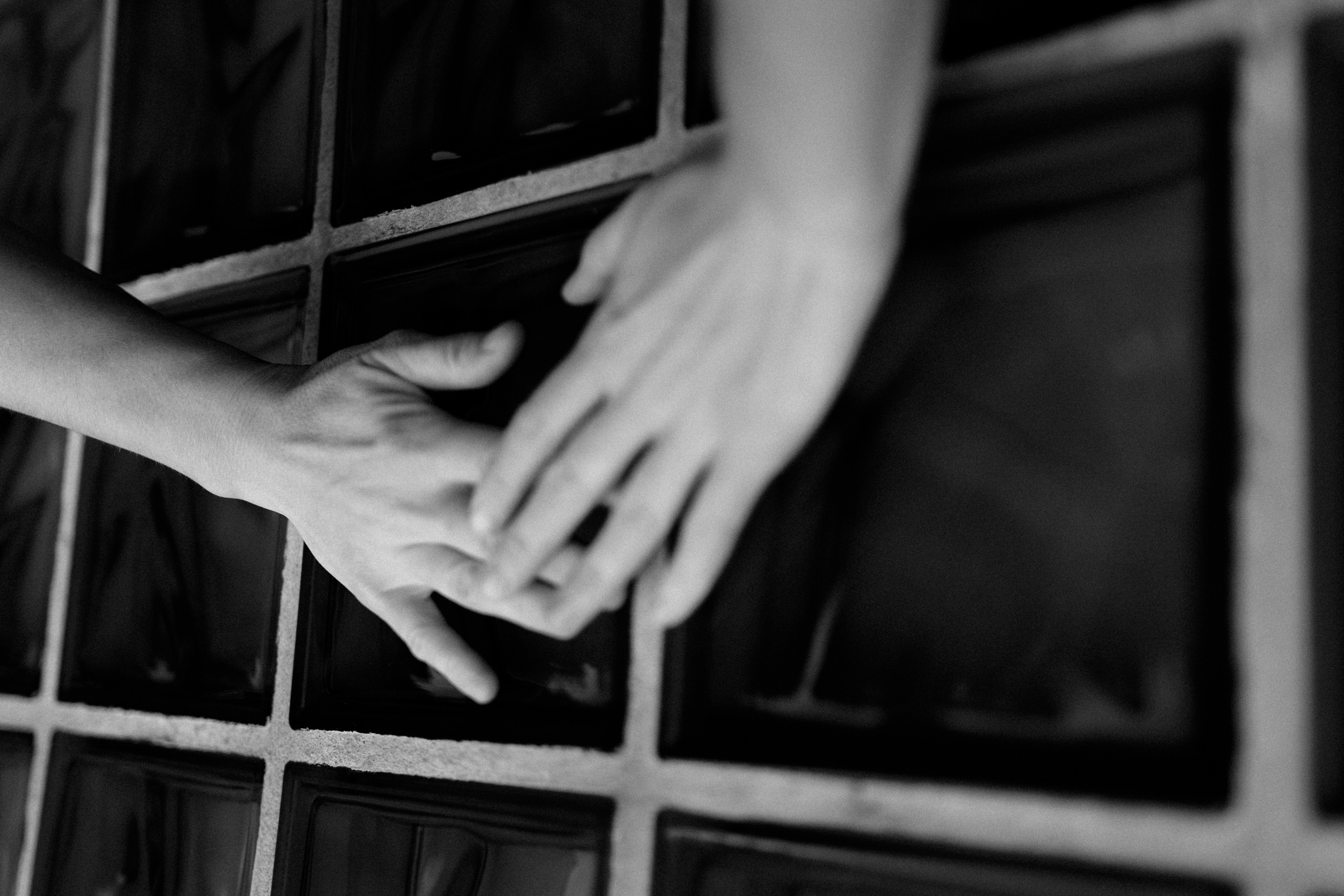 Hands in Quiet Reach Across Concrete Tiles