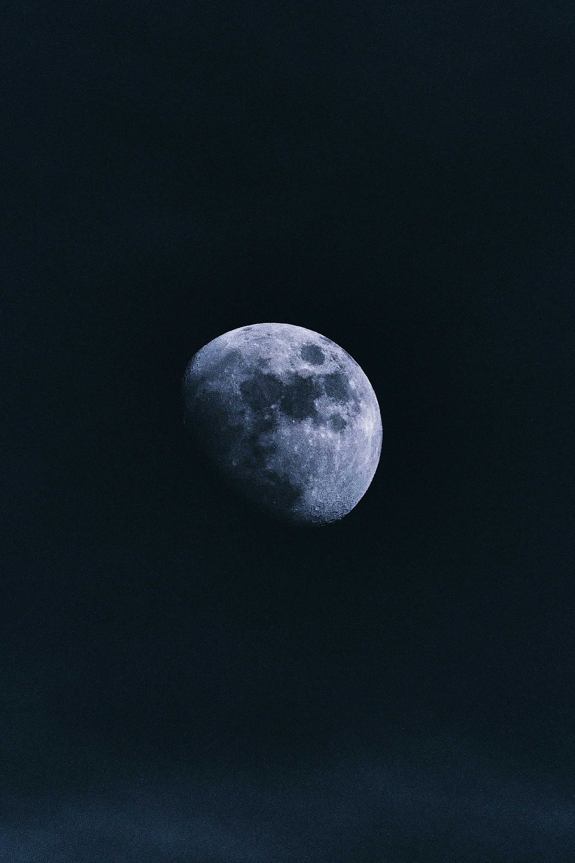 A waxing gibbous moon glowing against a dark night sky