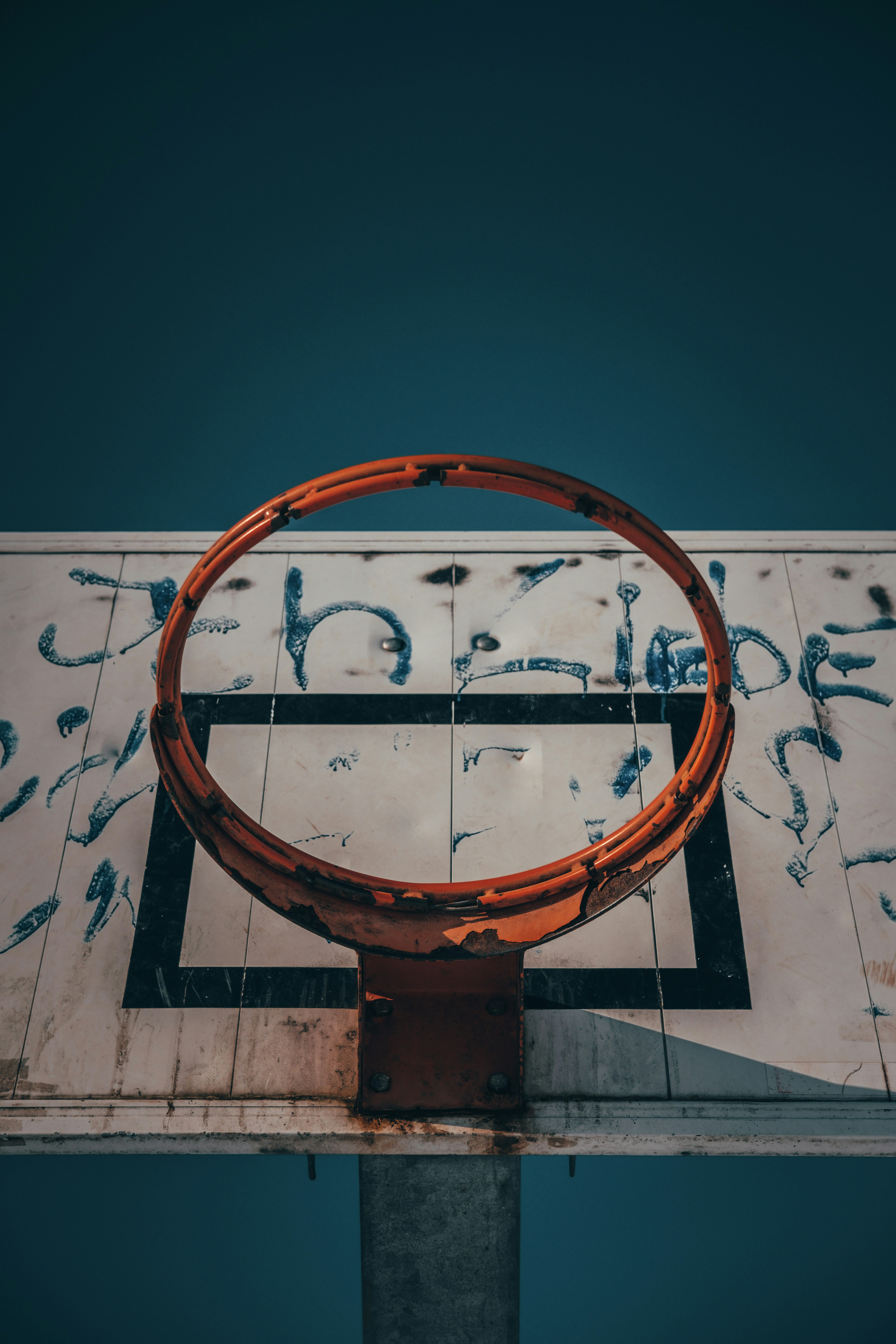 Hoop Ring Over a Weathered Court: Framed by Cracked Tiles and Graffiti