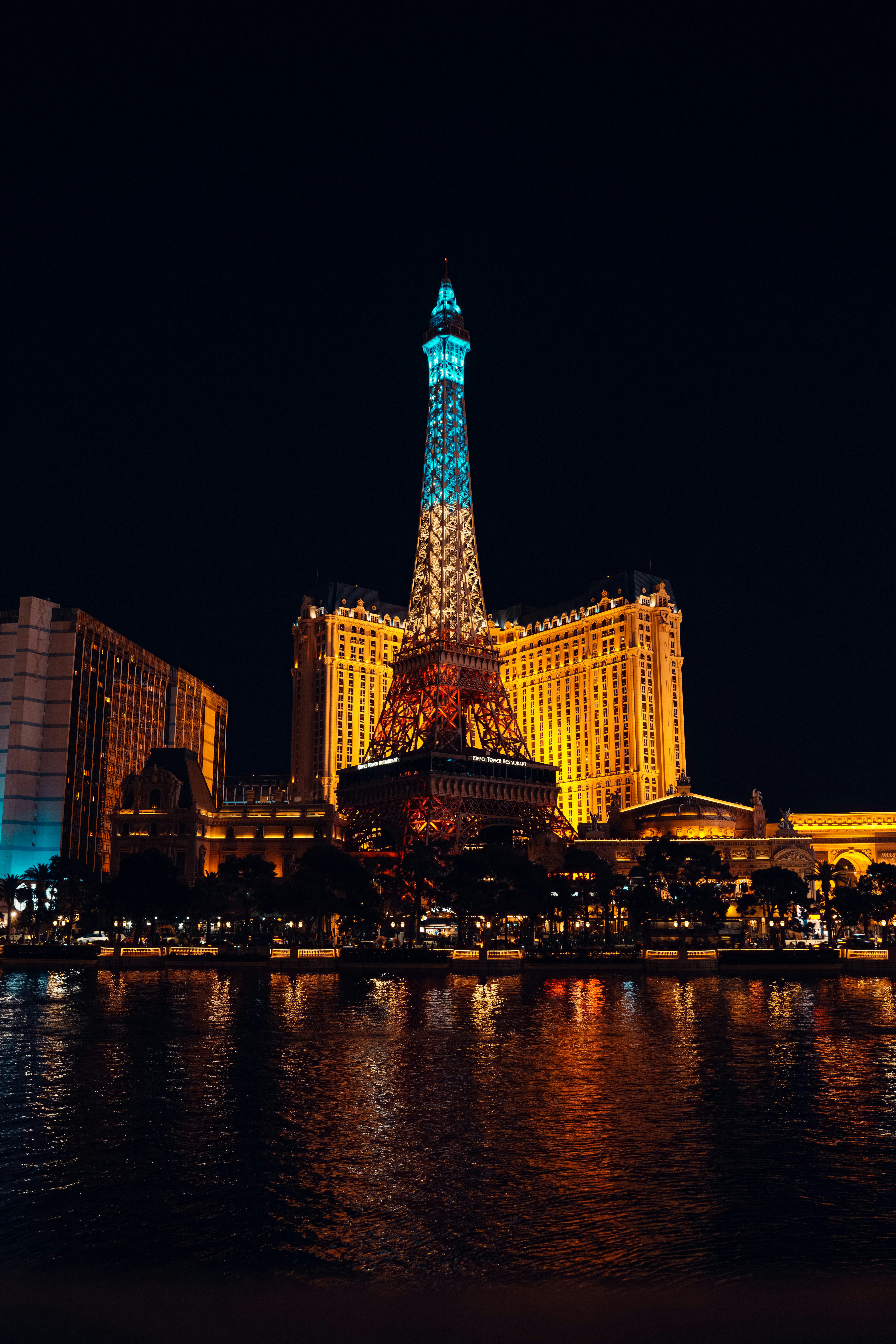 The Eiffel Tower replica illuminated in blue, white, and red at night in Las Vegas
