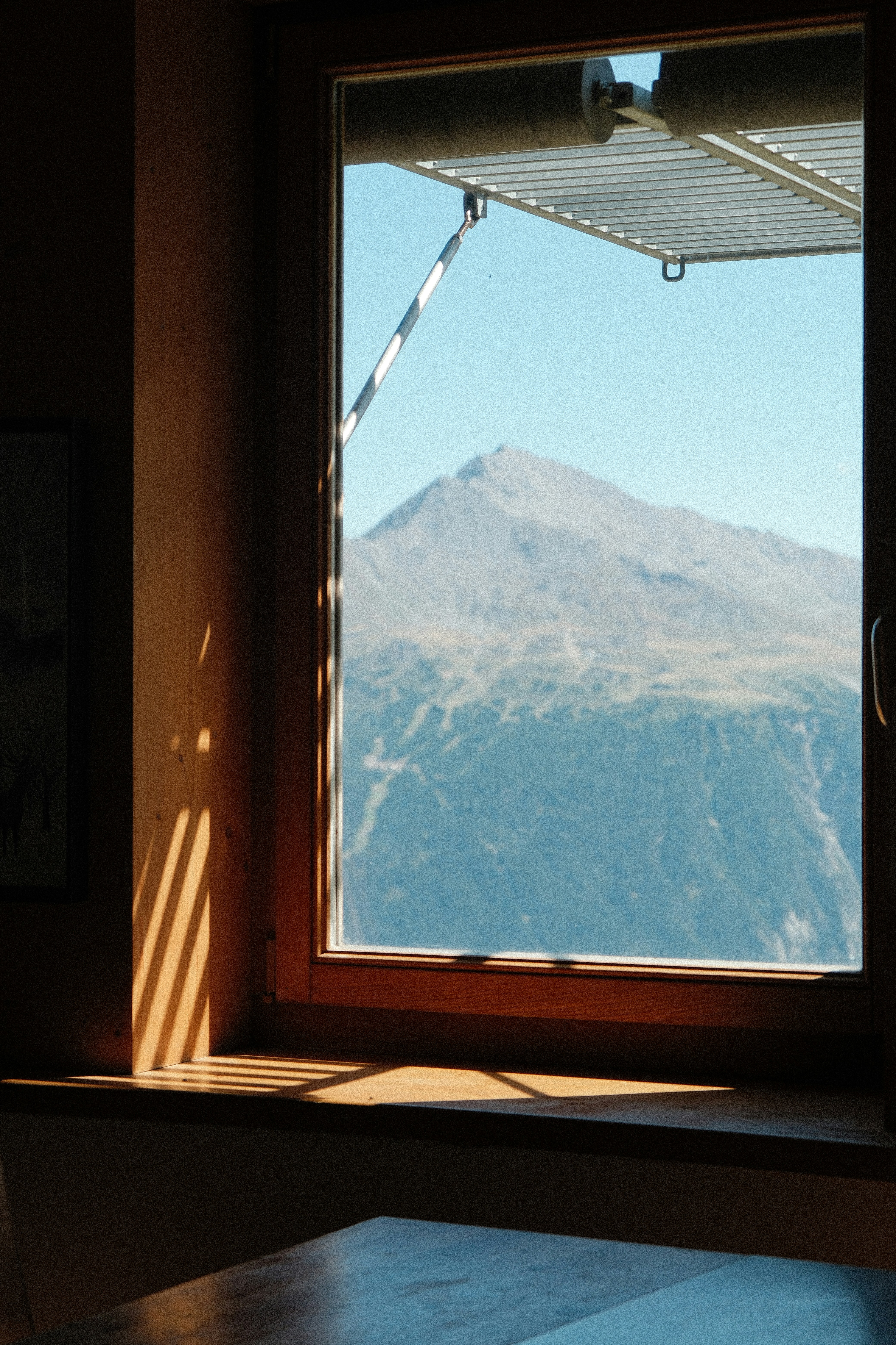 Window View: Mountain Peak Framed by Warm Interior Light