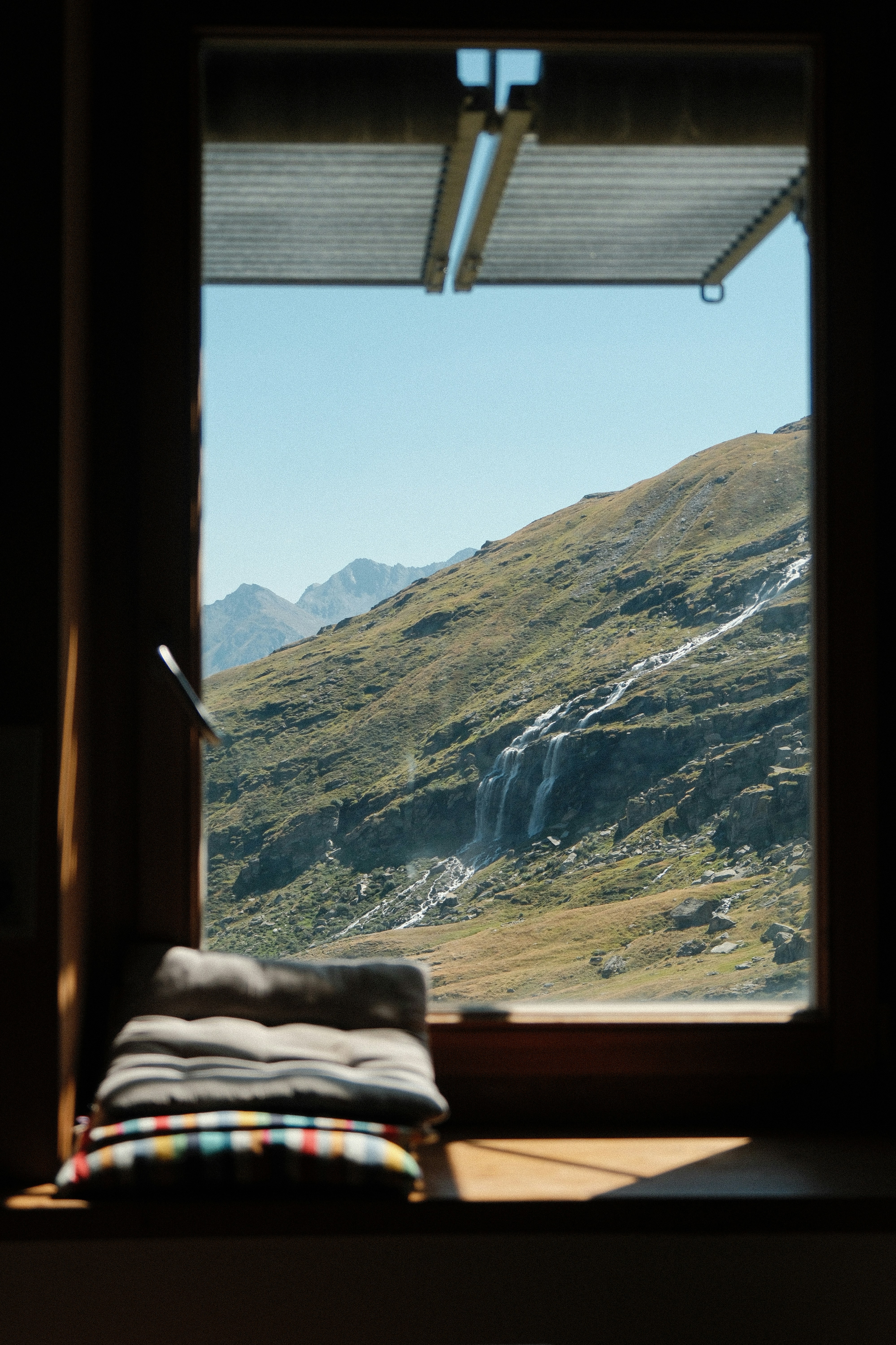 Window to the Highlands: Mountain Stream Framed by a Cozy Interior