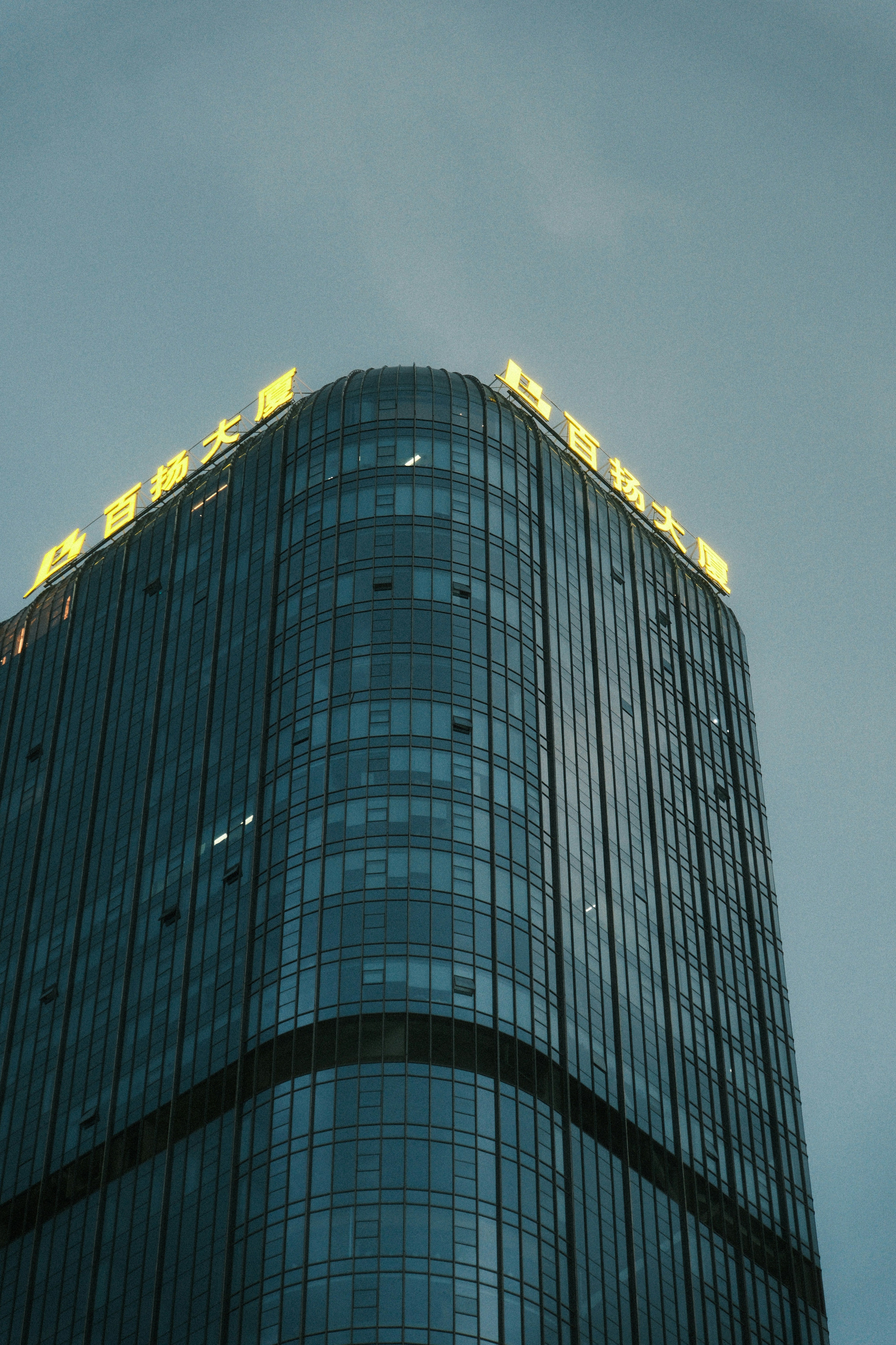 Vertical Peak: Glass Tower Wears Golden Signage