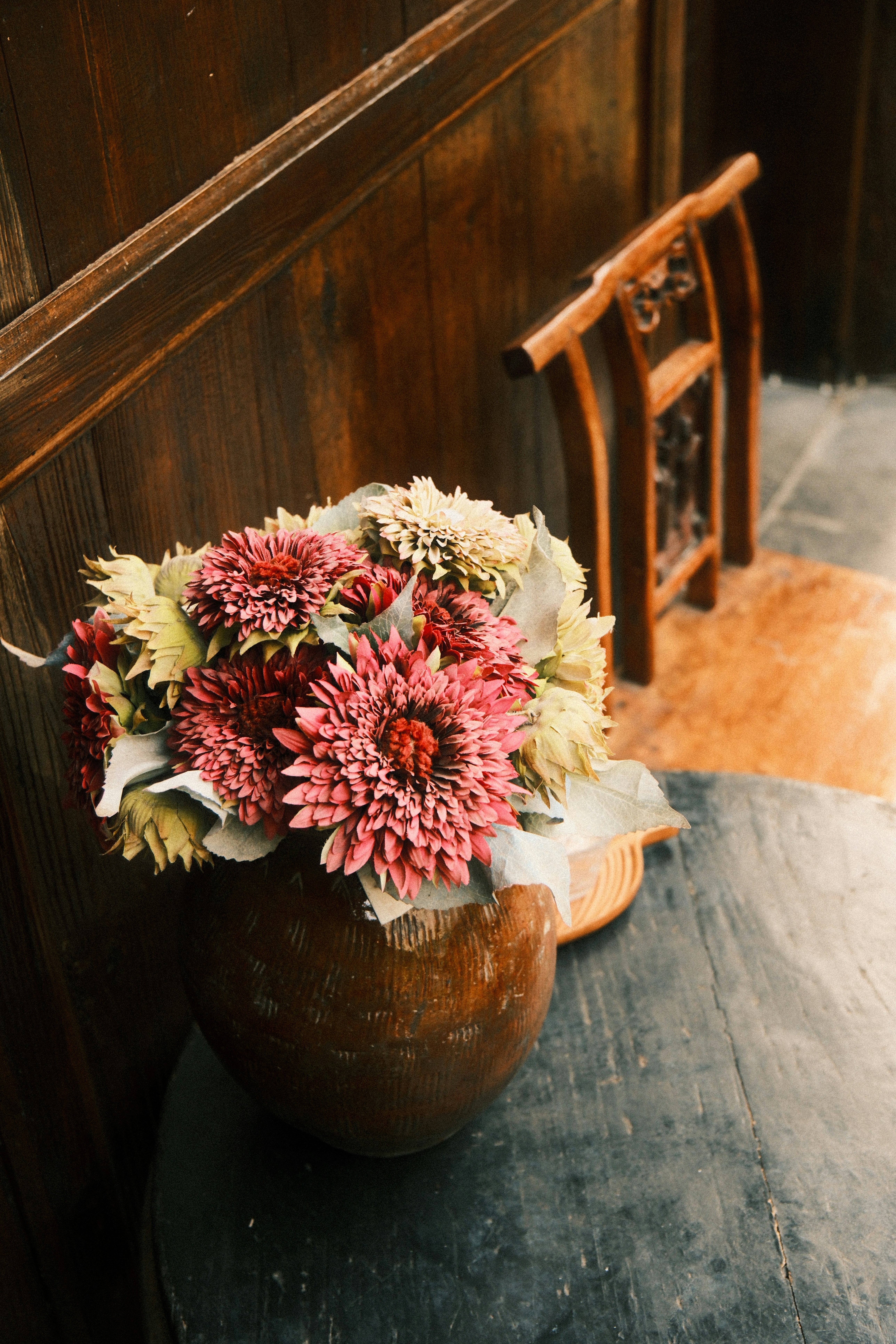Bouquet by the Wooden Wall: Crimson Blooms in a Rustic Setting