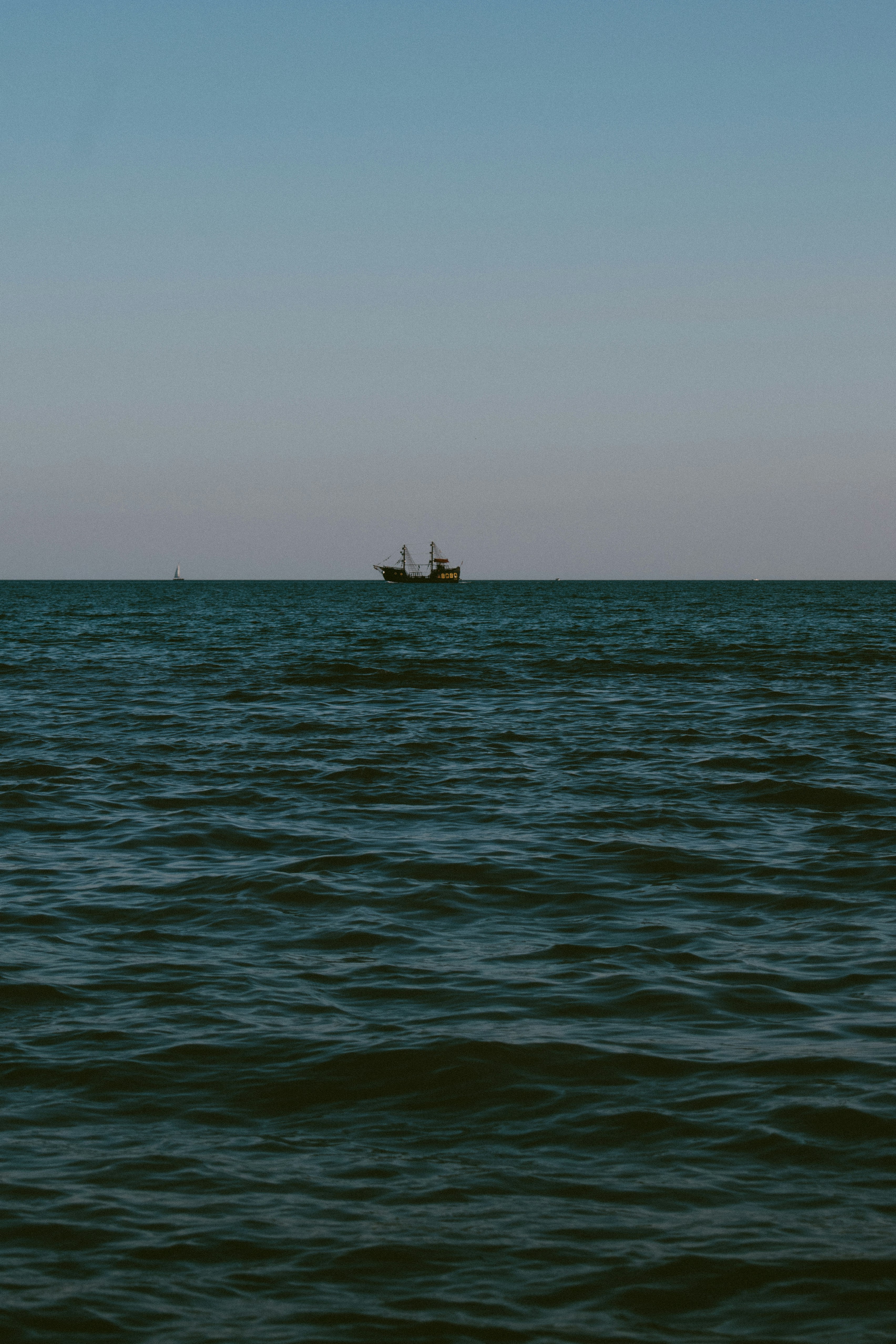 Distant Fishing Vessel on a Calm Sea Horizon