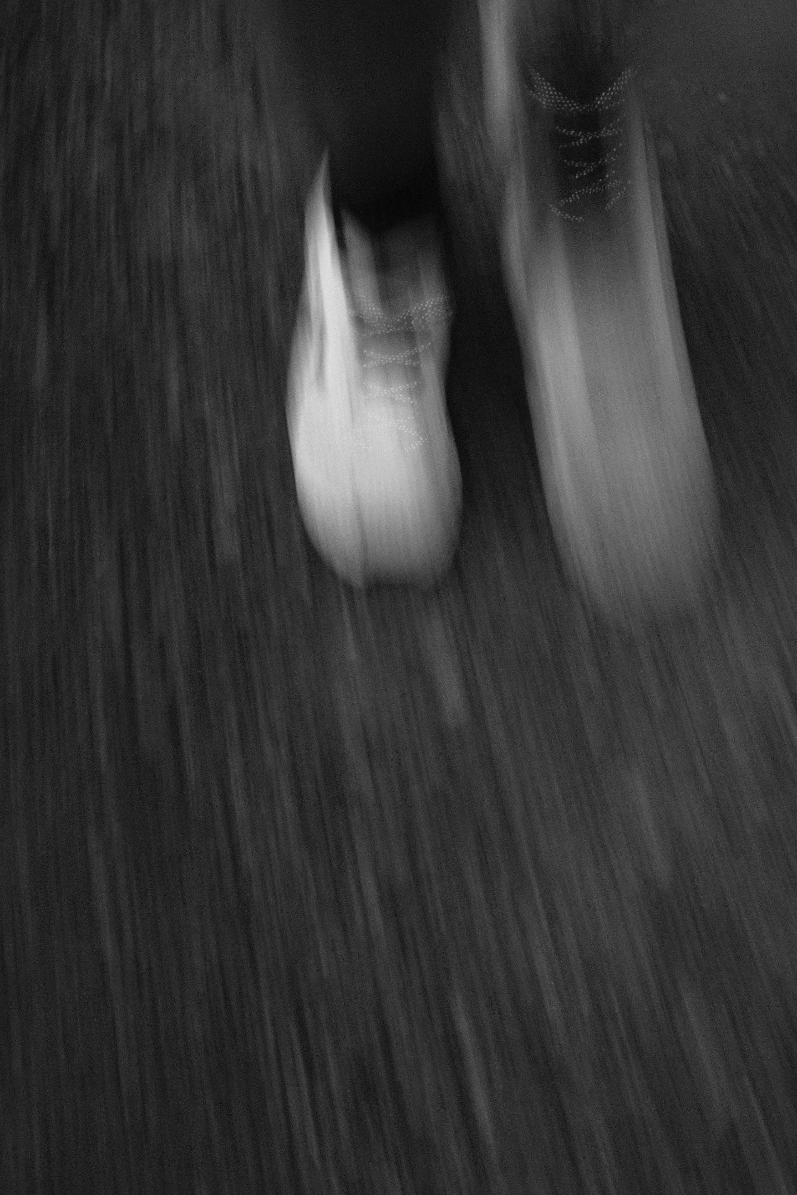 Stumbling Steps in Motion: A Blurred Footscene on a Dim Street