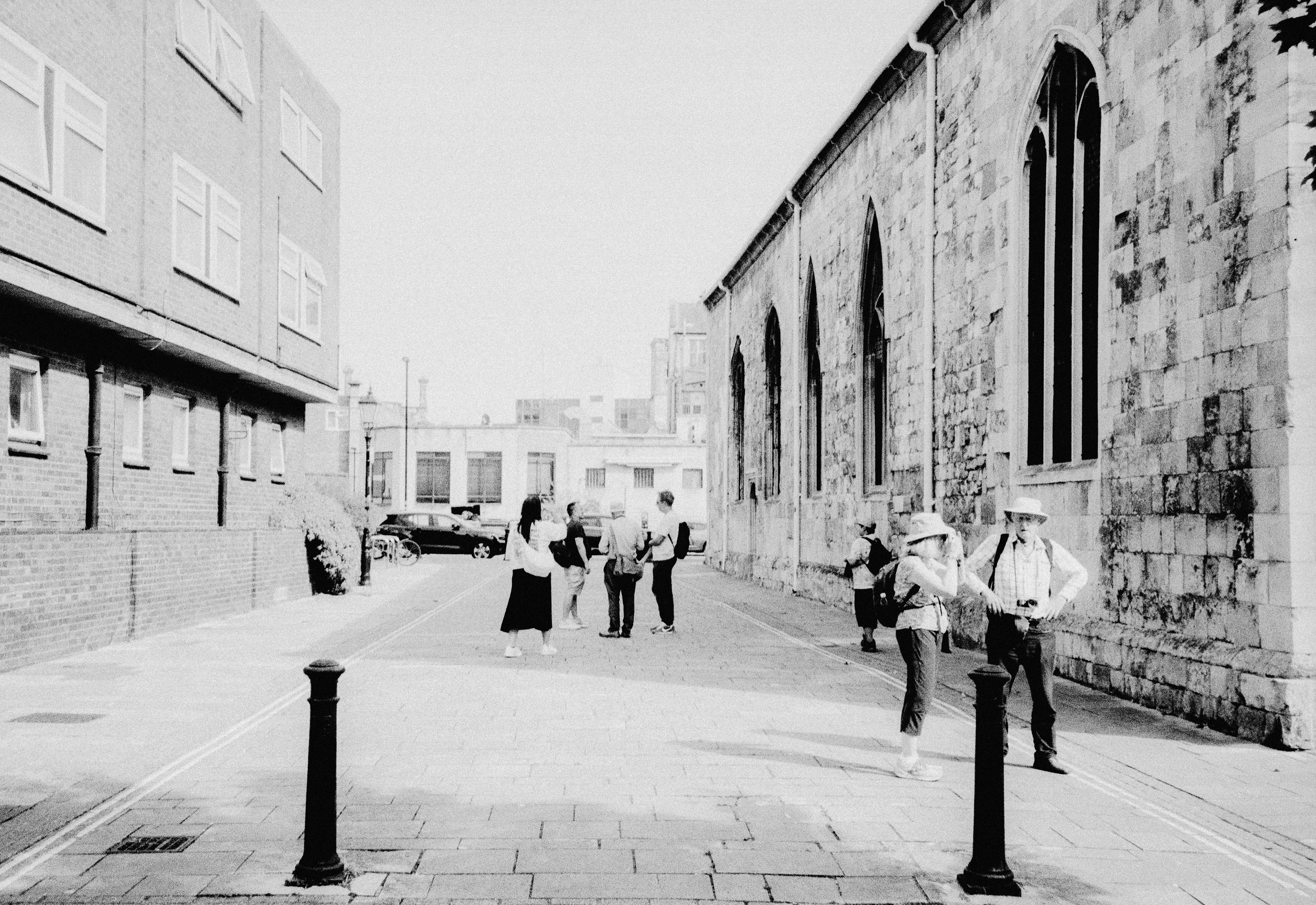 Urban Assembly in Monochrome: A Quiet Meeting by the Heritage Wall