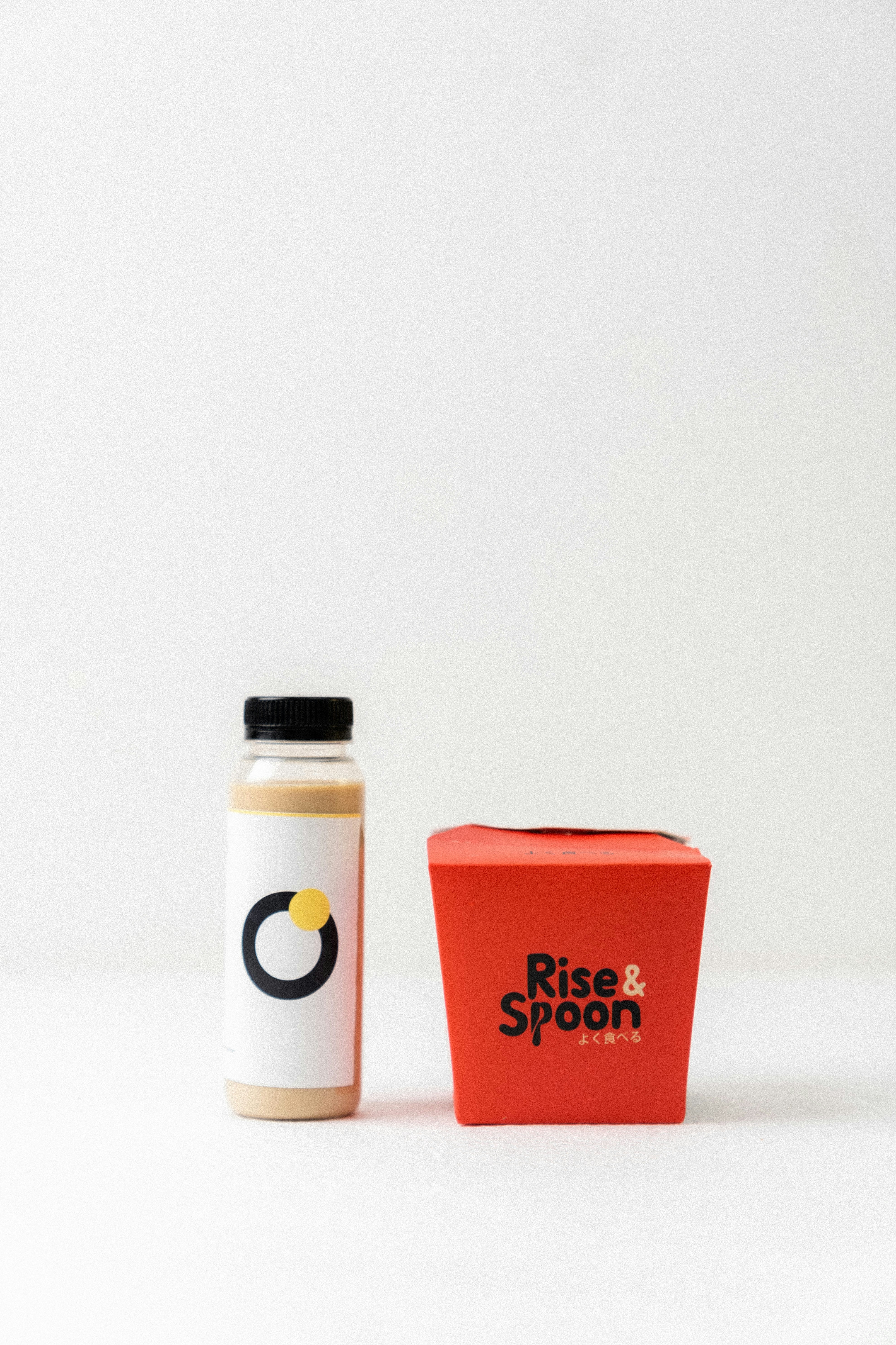 Tiny Beverage Duo: A Bottle and a Red Meal Kit Stand Shoulder to Shoulder