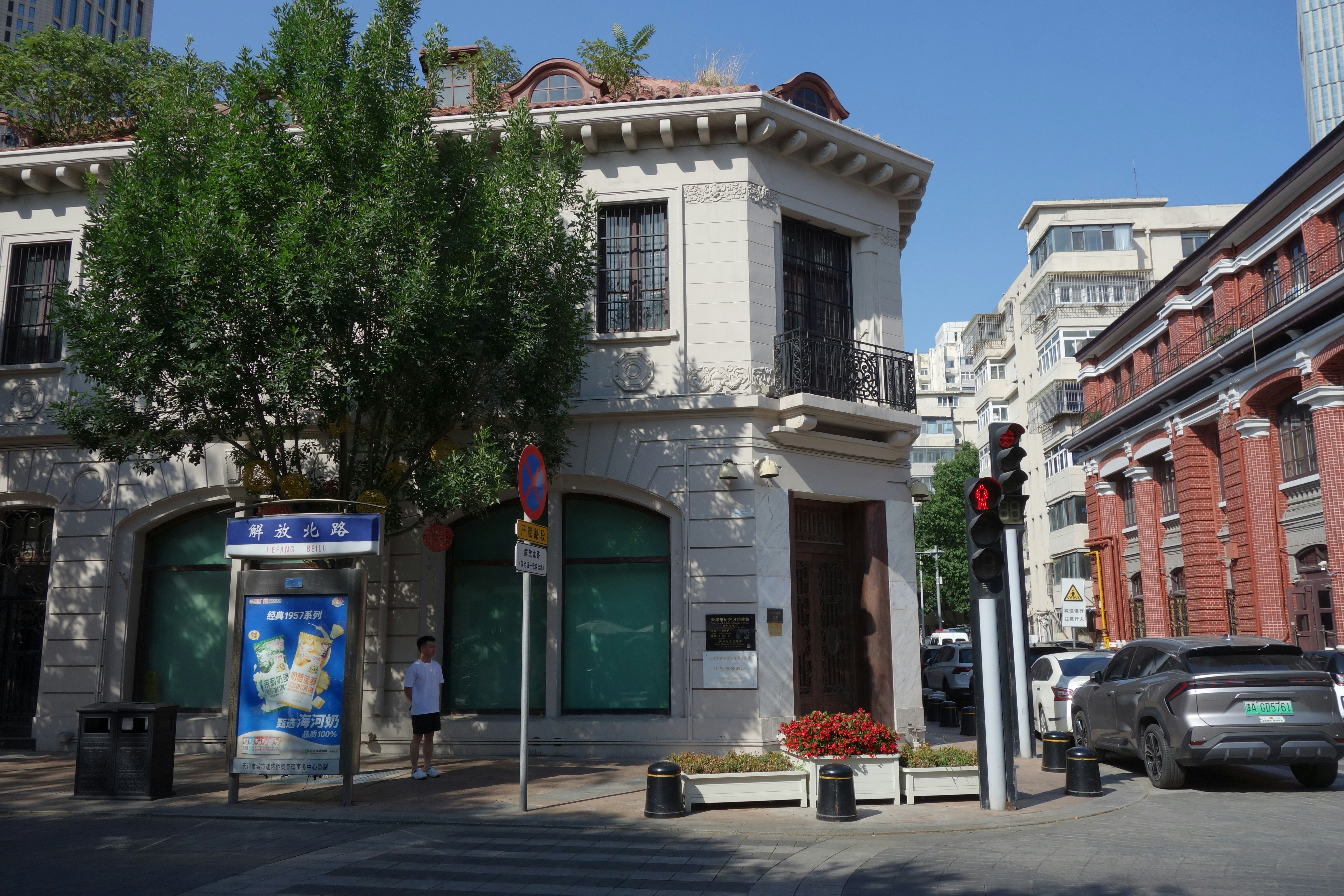 Sunlit Corner: A Cornerstone Building with Green Shutters Under a Clear Blue Sky