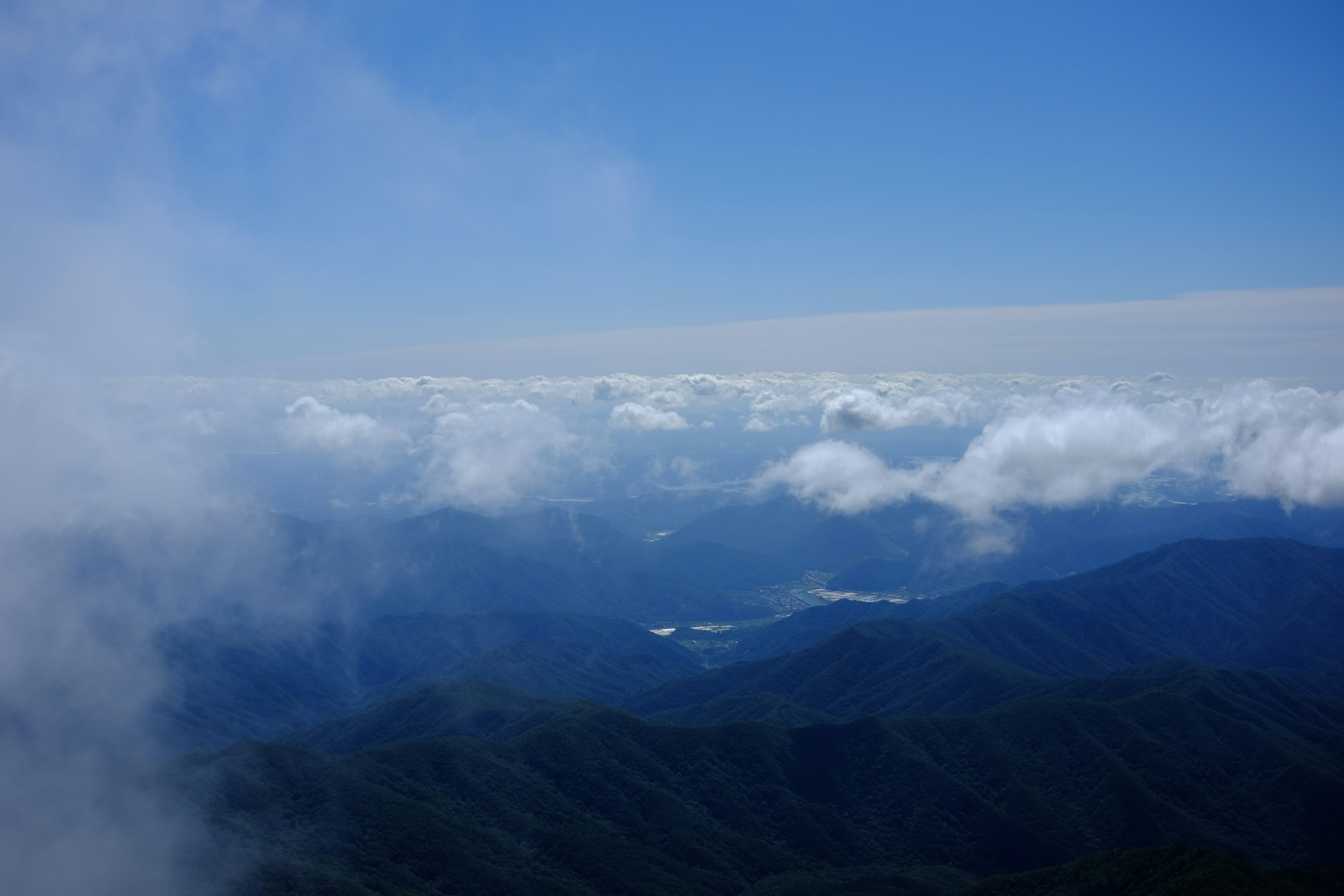Misty Alpine Horizon Above a Ribbon of Clouds