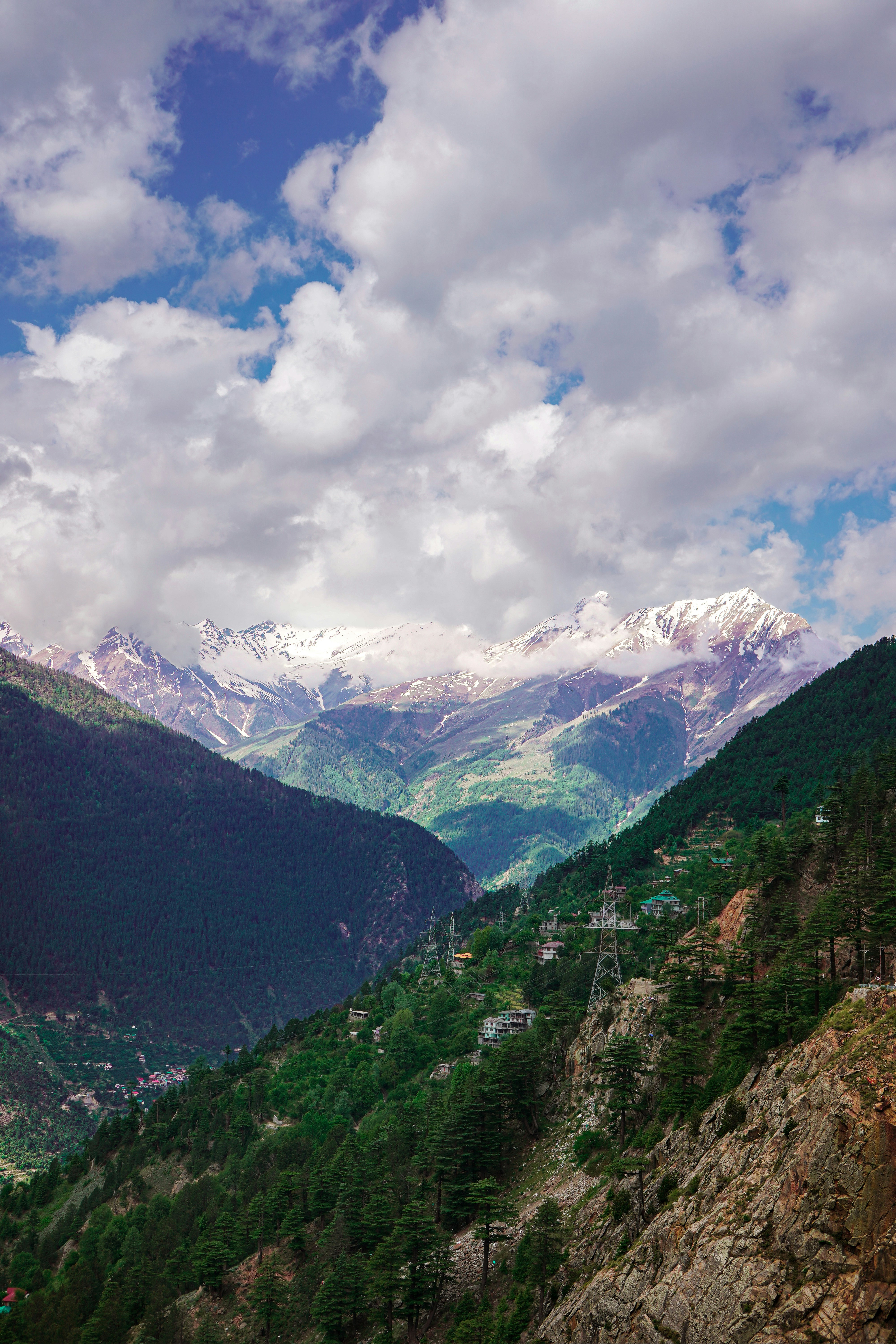 Snow-capped peaks and winding valley beneath a dramatic sky