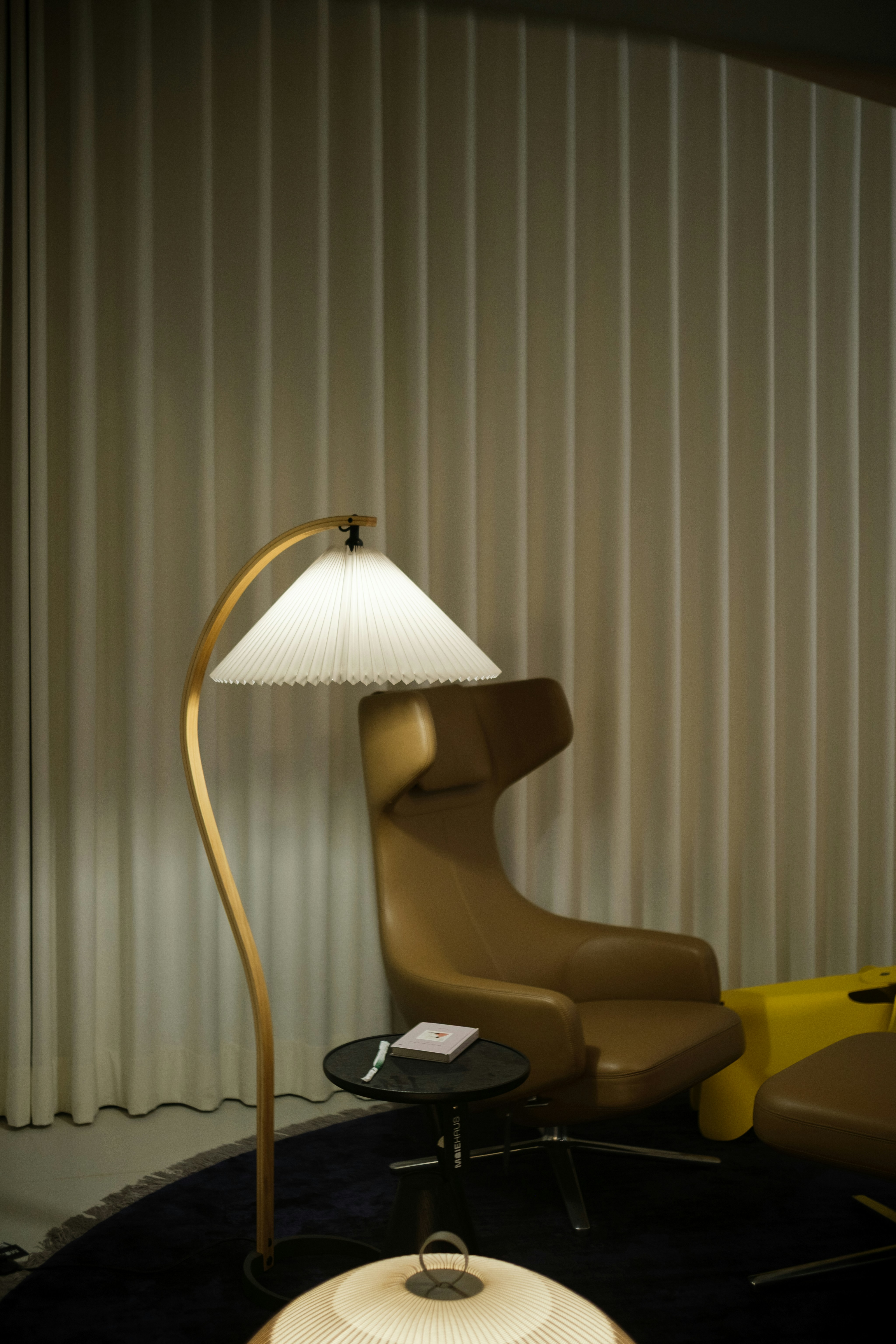 Warm Corner: A Curved Lamp Illuminates a Lounge Armchair