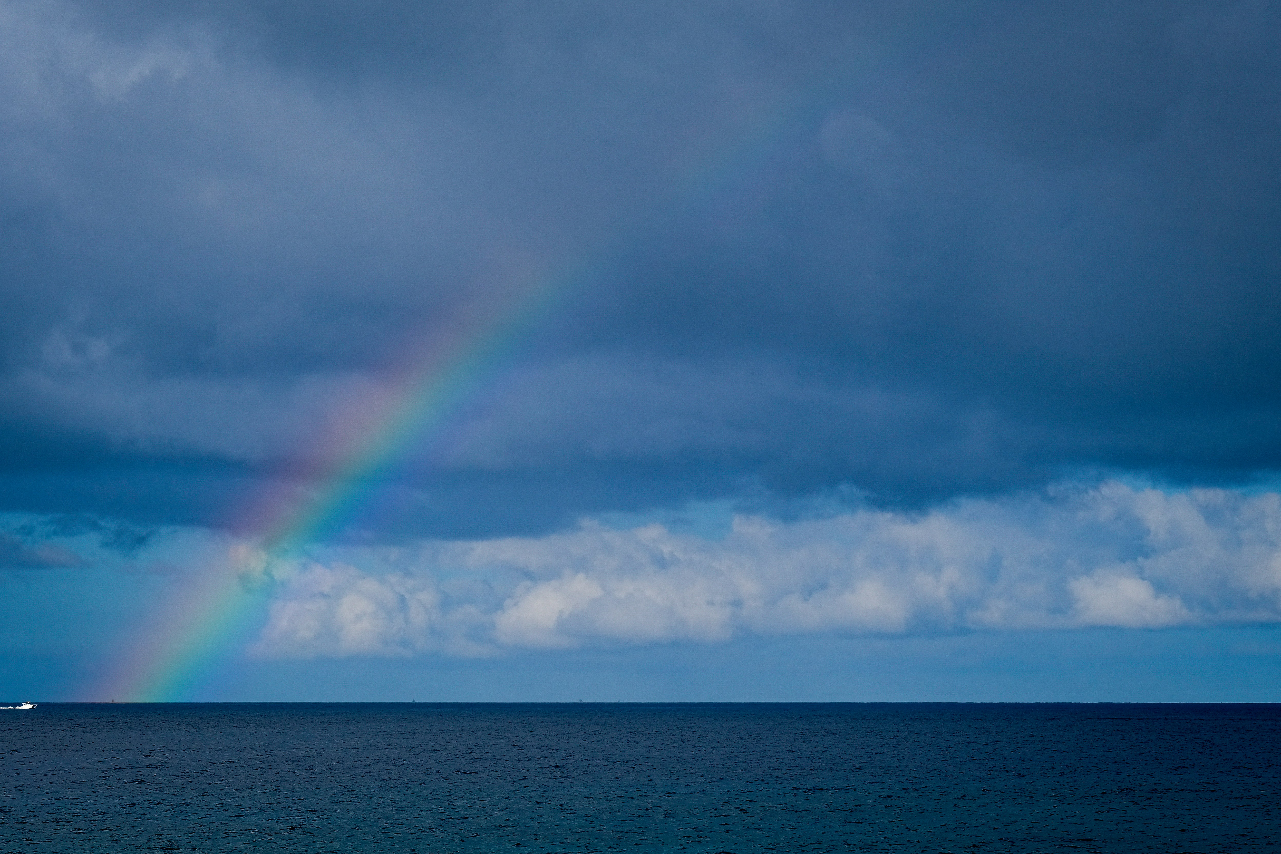 Arc Over the Sea: Rainbow SkiesMeeting the Horizon