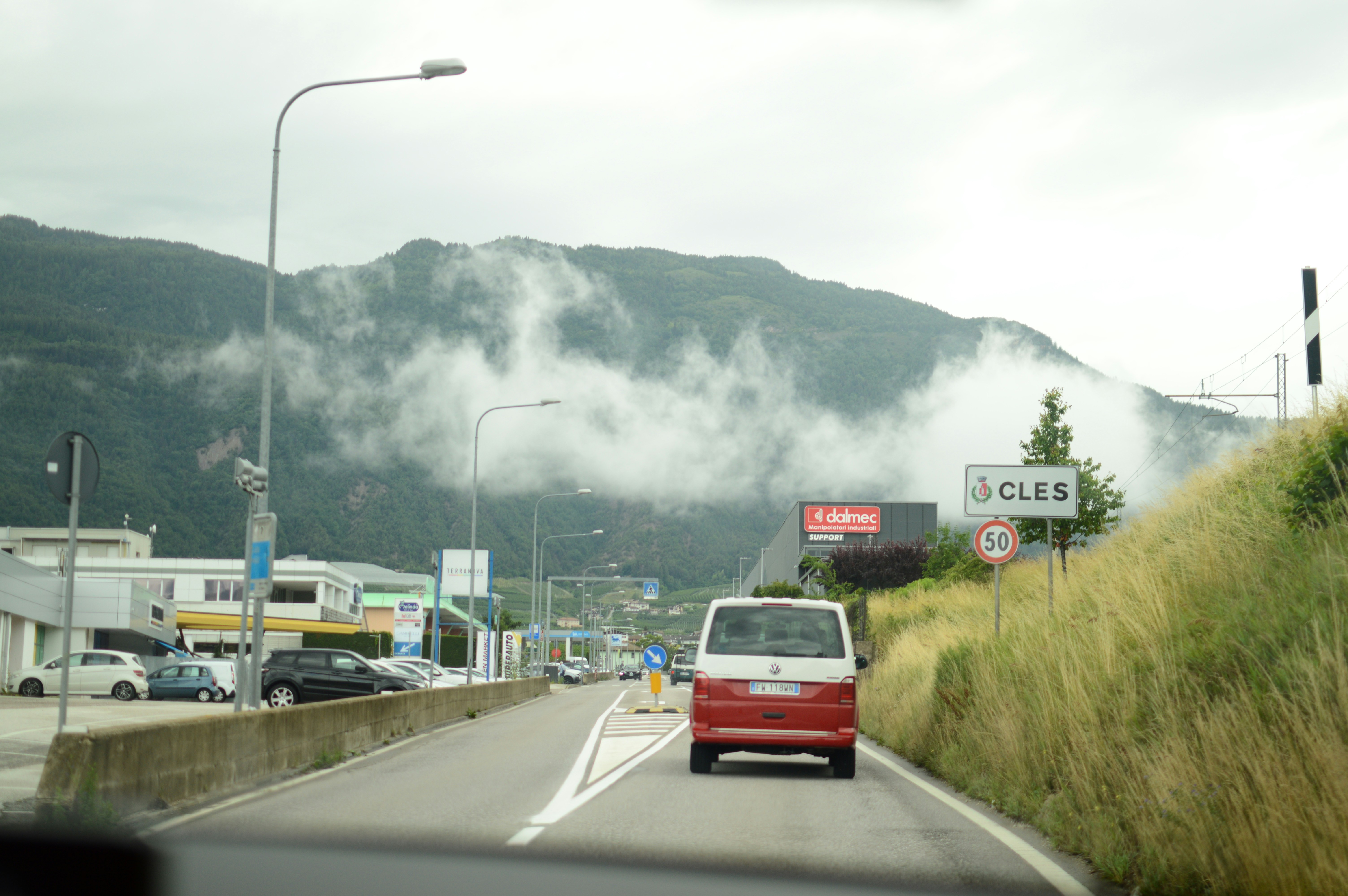 Red Van on a Mountain Road Beneath Misty Hills