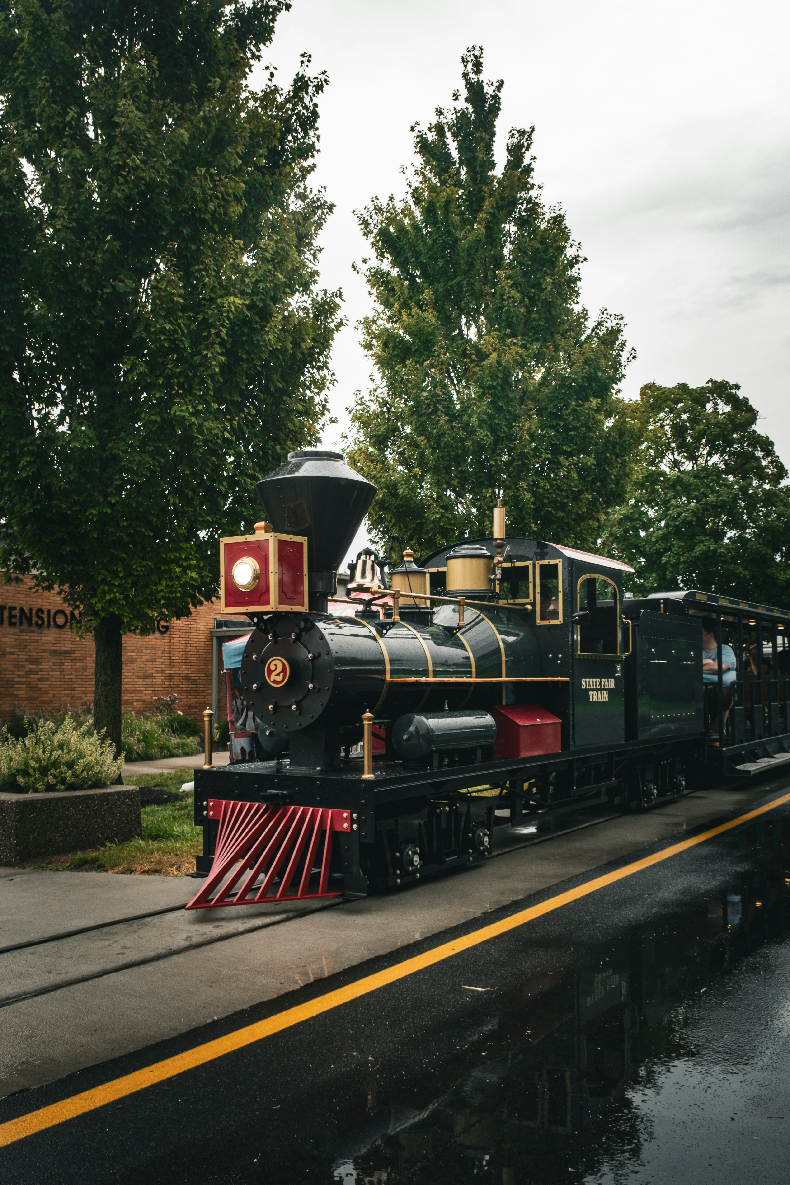 First Run on the Rails: A Vintage Steam Engine at a Wet, Leafy Station