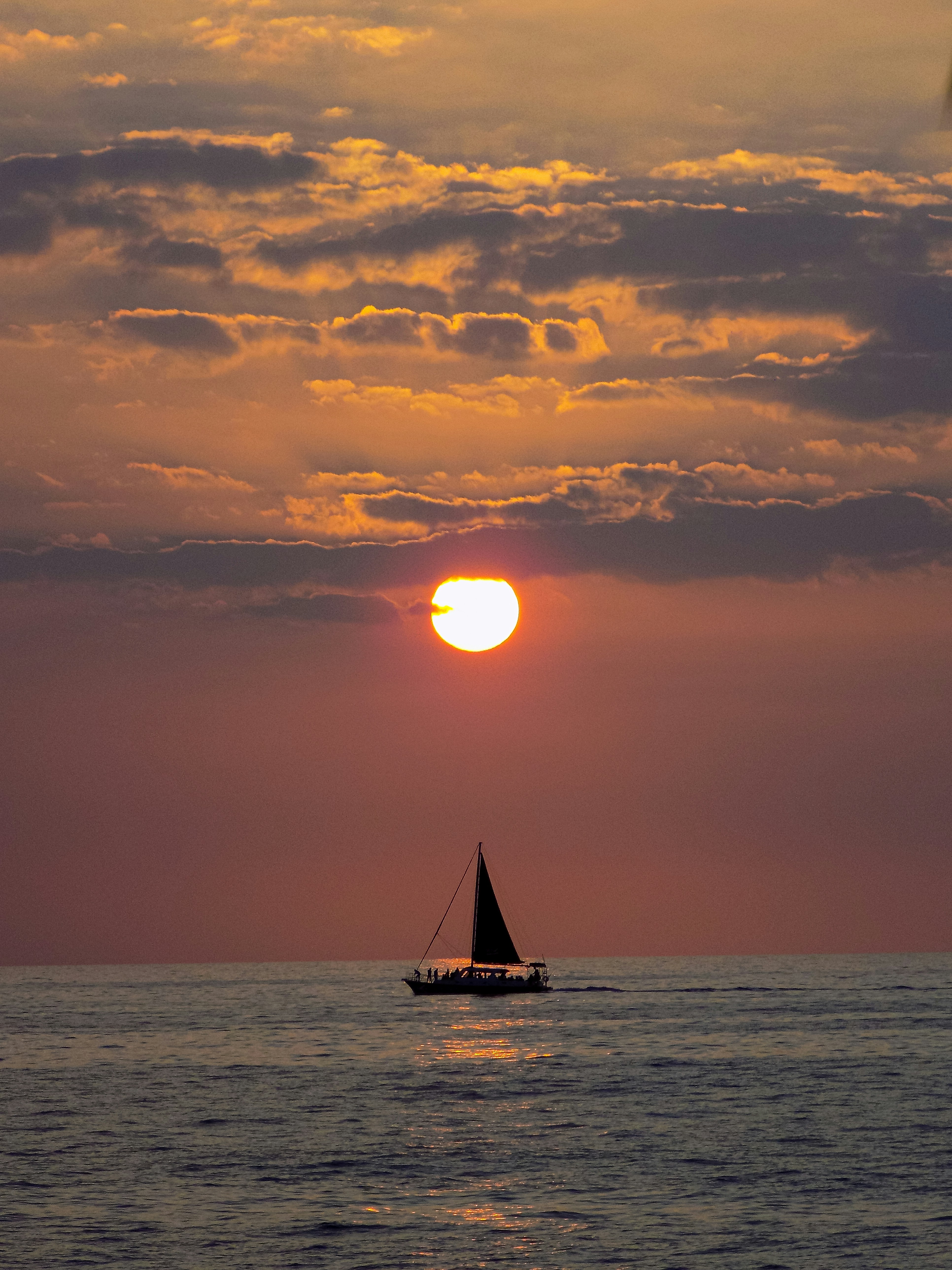 Sailboat at Dusk: Silhouette and Sunlit Horizon