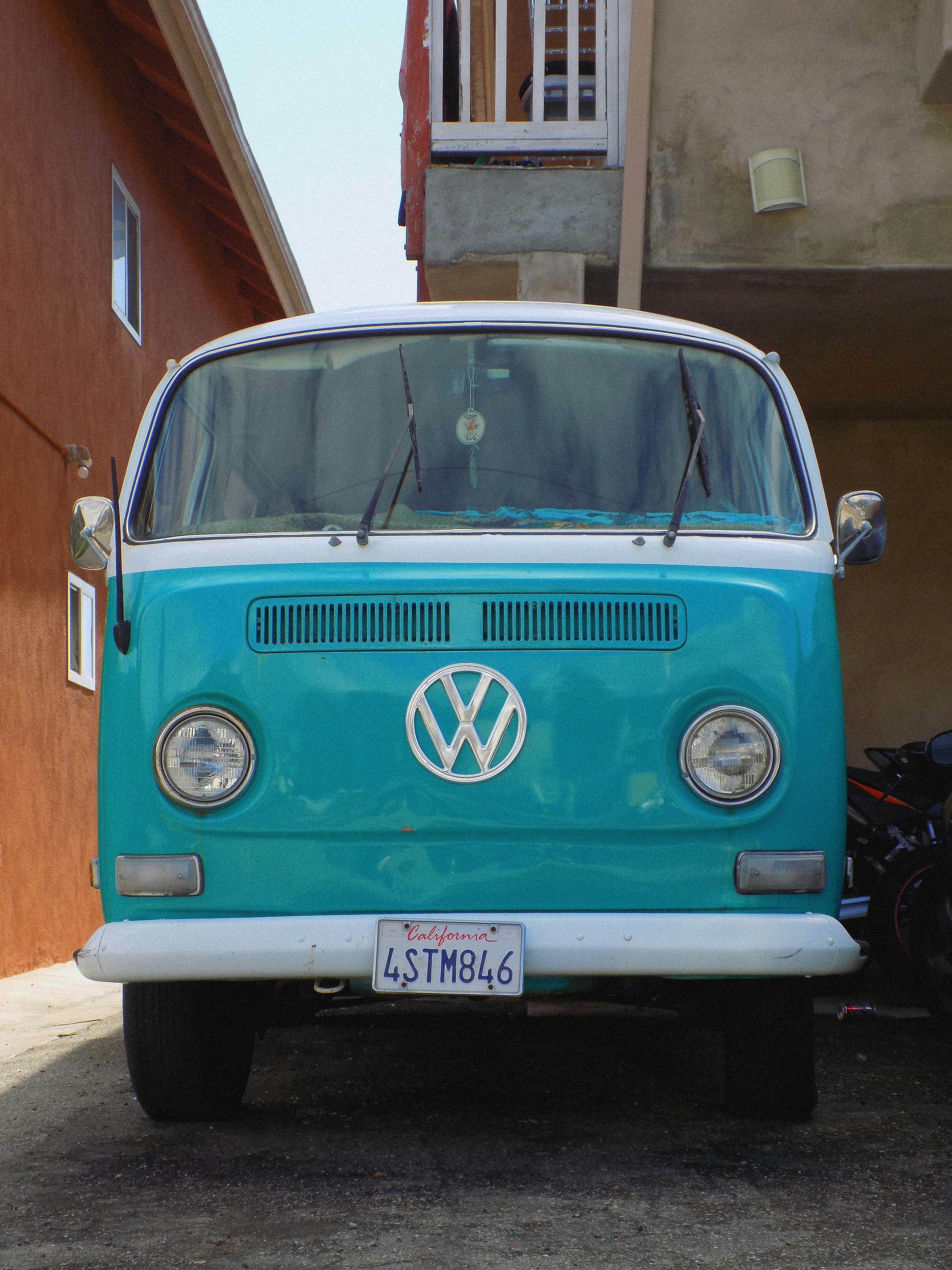 Turquoise VW Bus at the Gate: A Retro Moment in Orange Courtyard