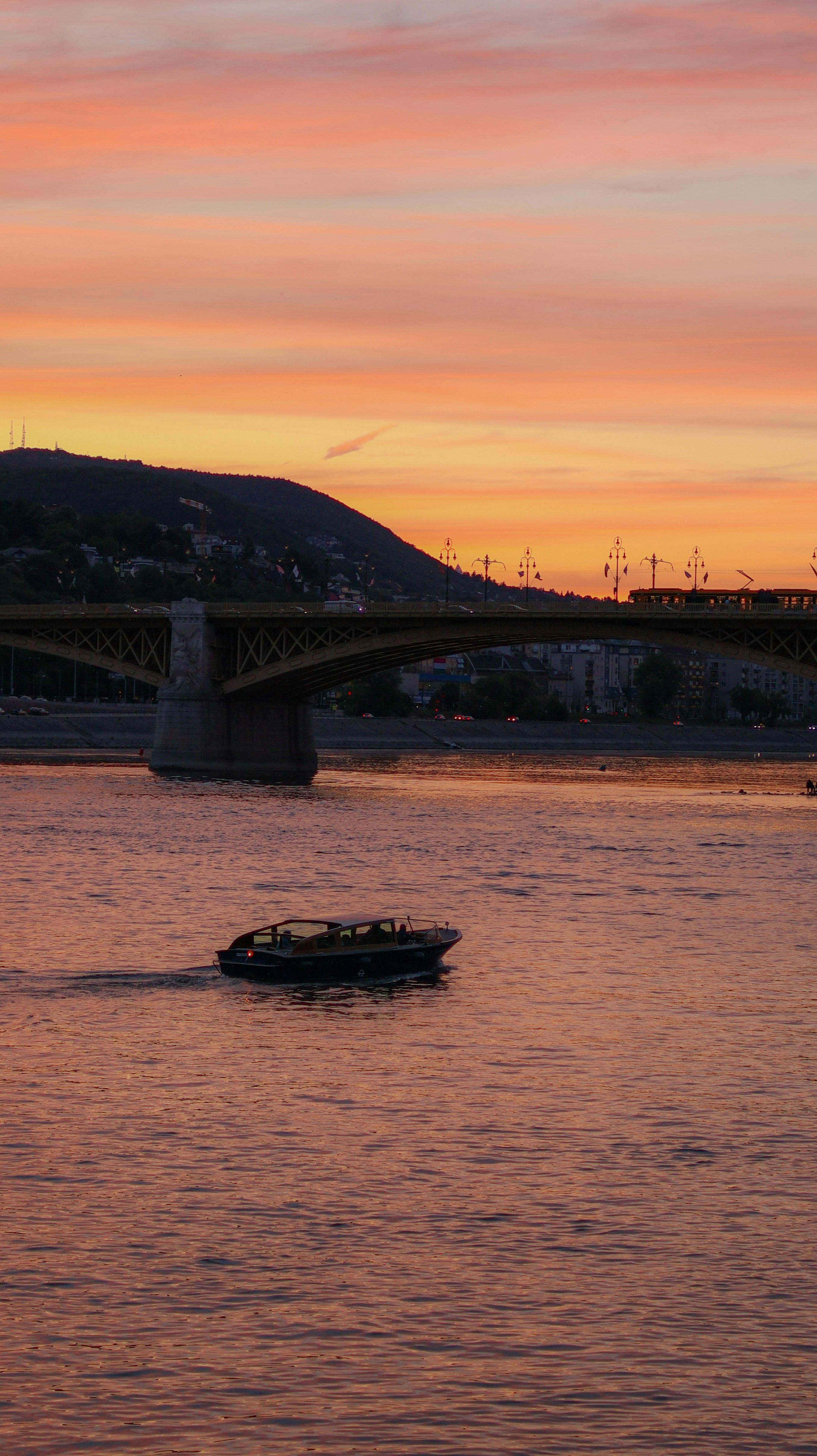 Evening River Crossing: A Boat Under the Silent Bridge at Sunset