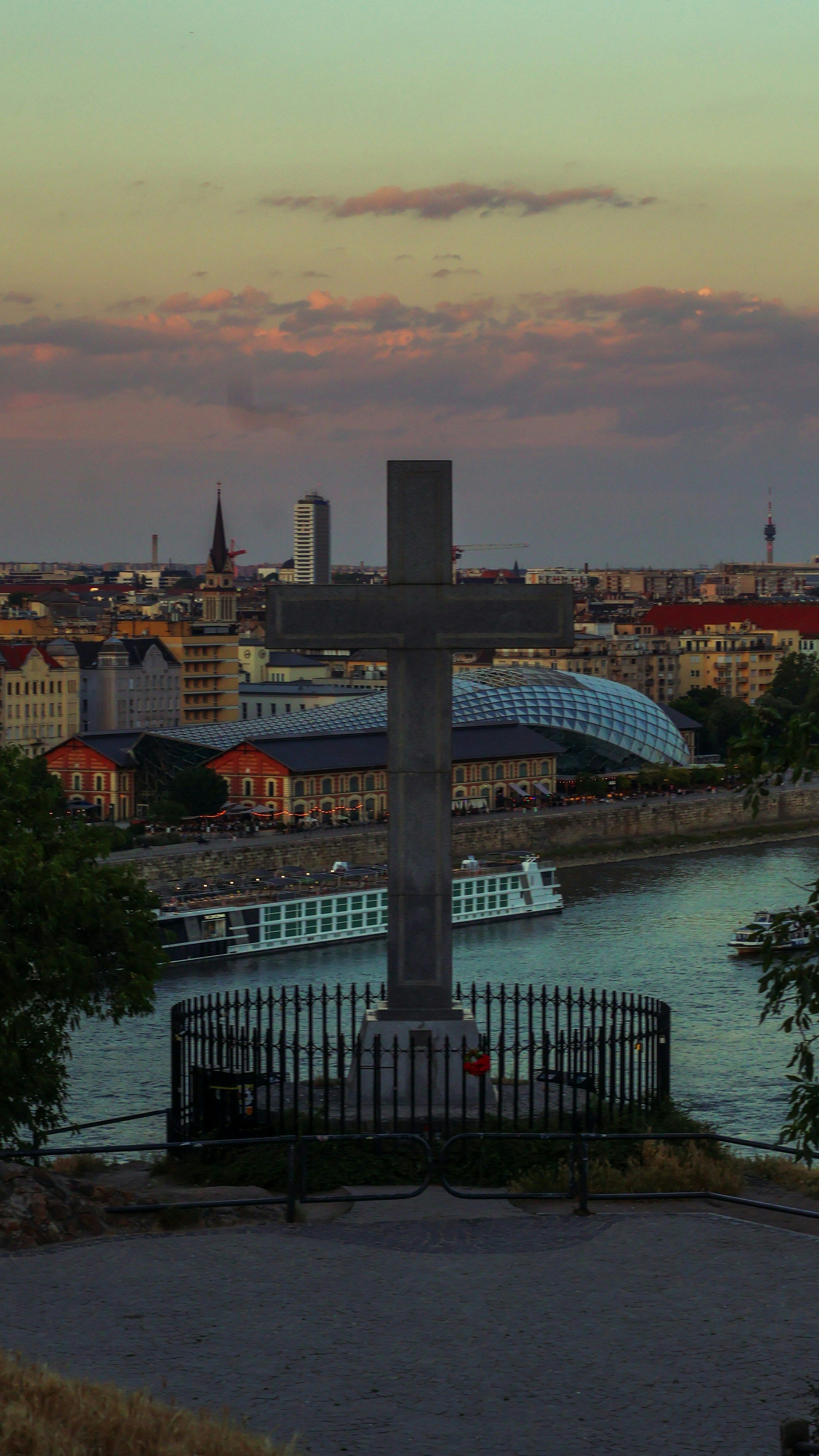 Cross on the Riverfront: Sunset over a Historic City