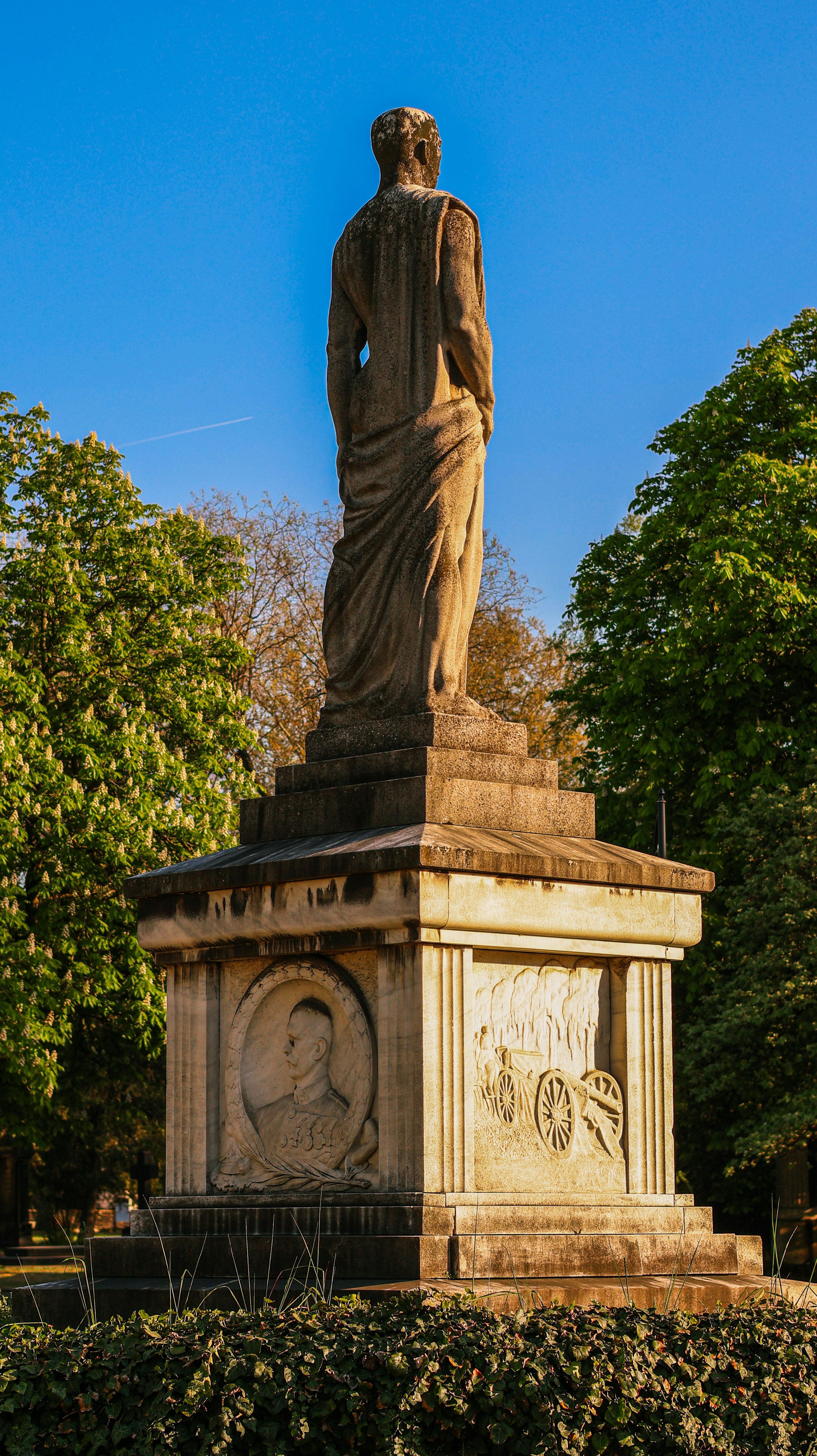 Stone Sentinel: A Statue Reaching Toward a Clear Blue Sky