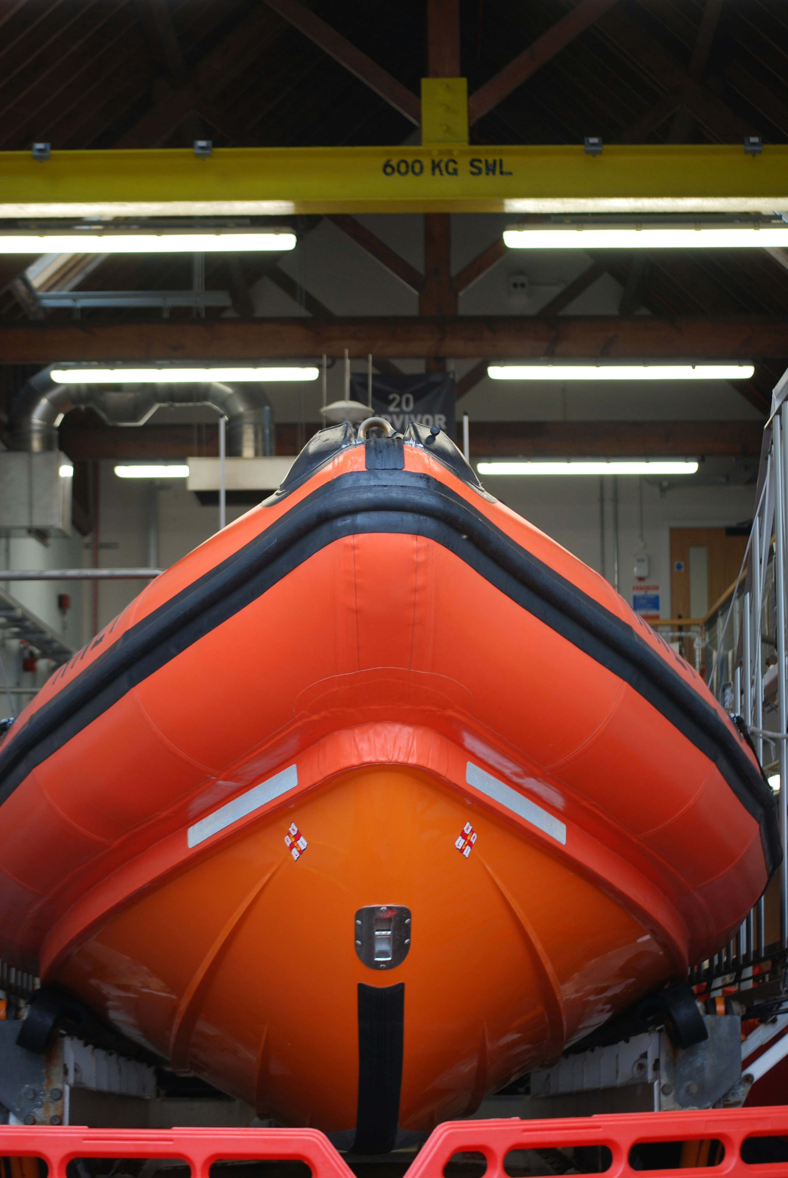 Orange lifeboat in a shipyard embrace