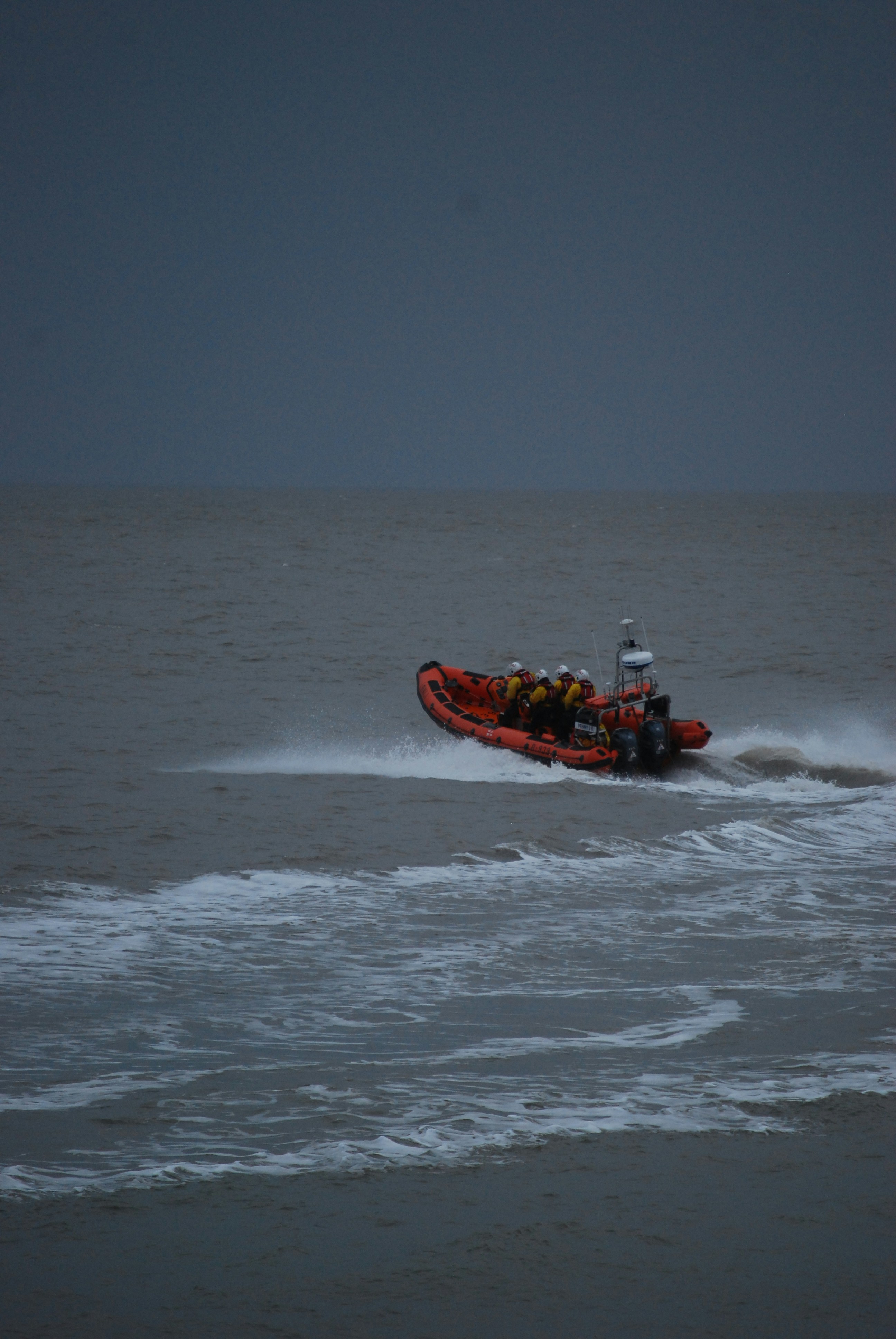 Red Rescue Vessel Cutting Through Grey Seas