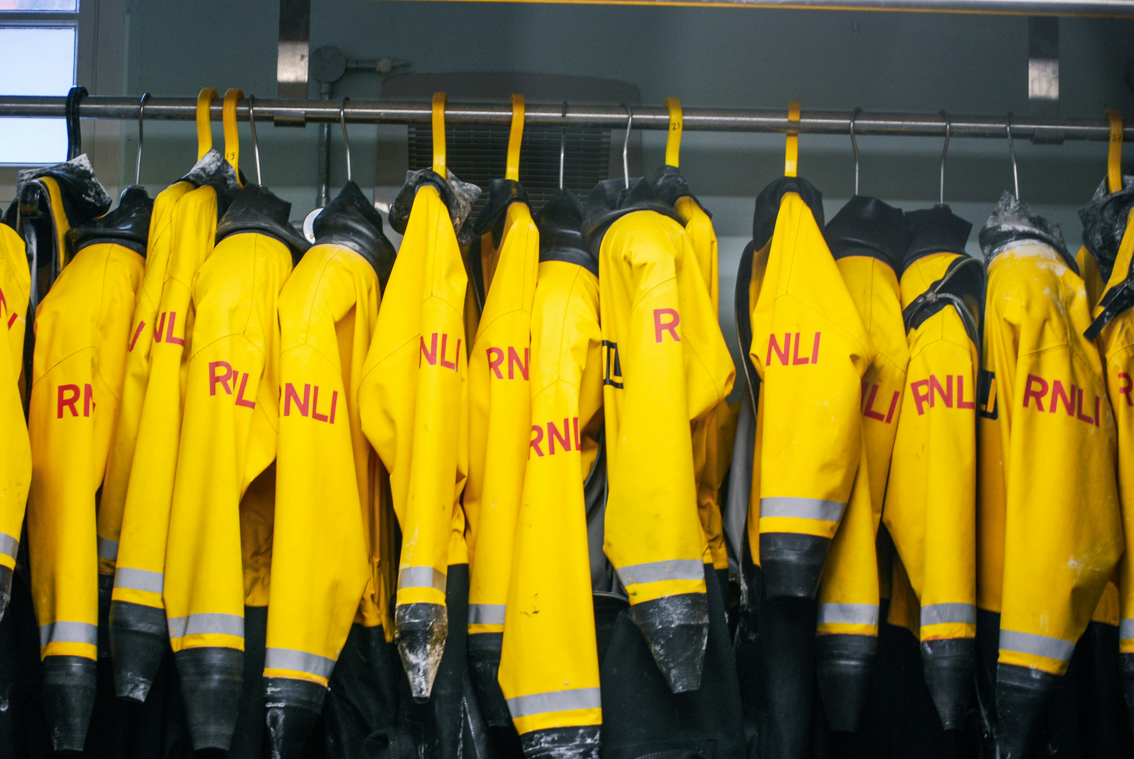 Uniform Row: Bright Yellow Fire Jackets Hang on a Rail